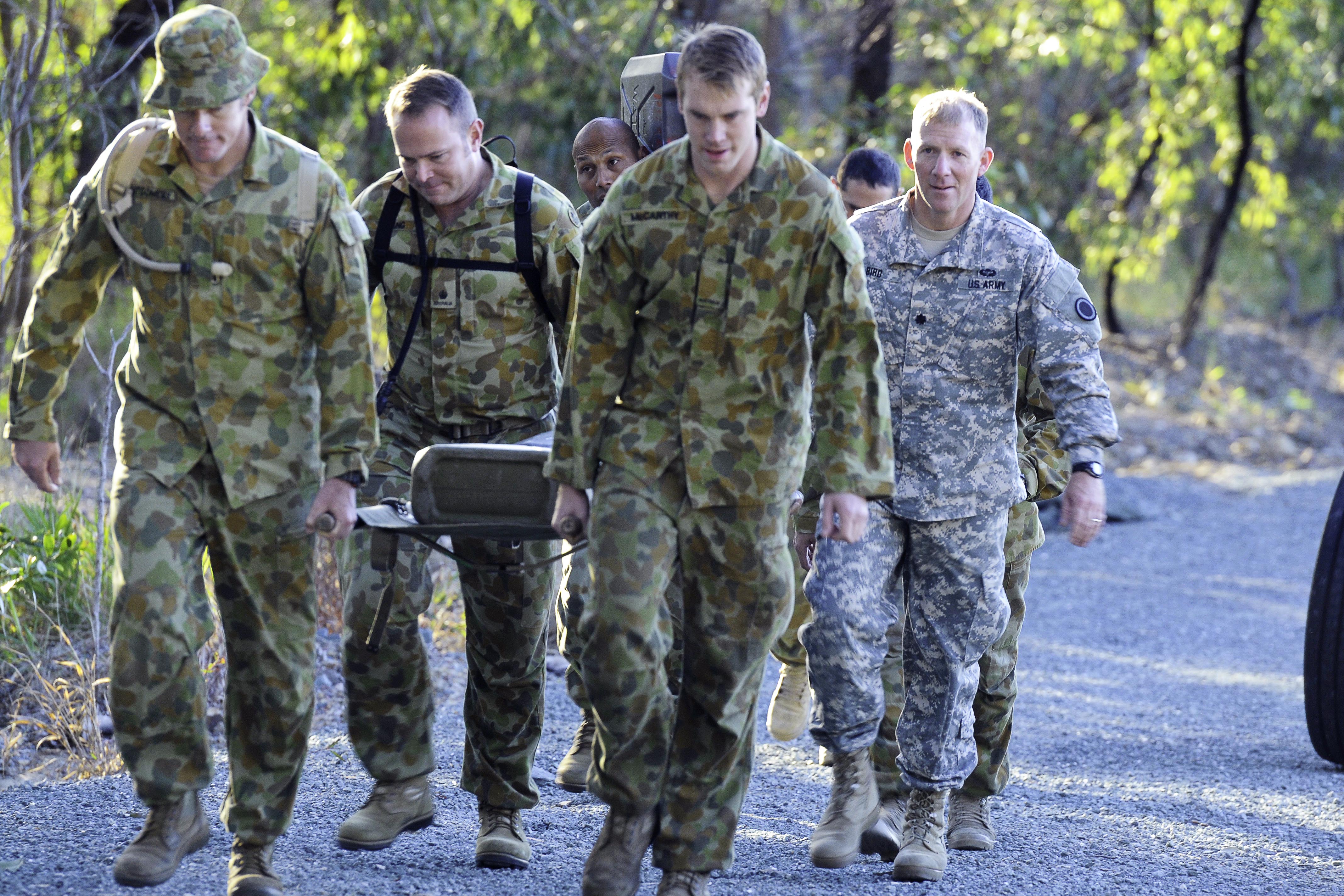 U.S. Army Lt. Col. Ben Bird, right, carries a litter with two 5-liter ...