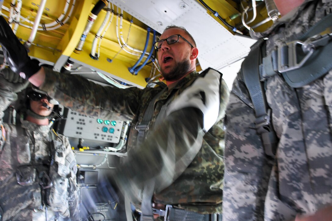 A German jumpmaster gives commands to U.S. Army paratroopers during ...