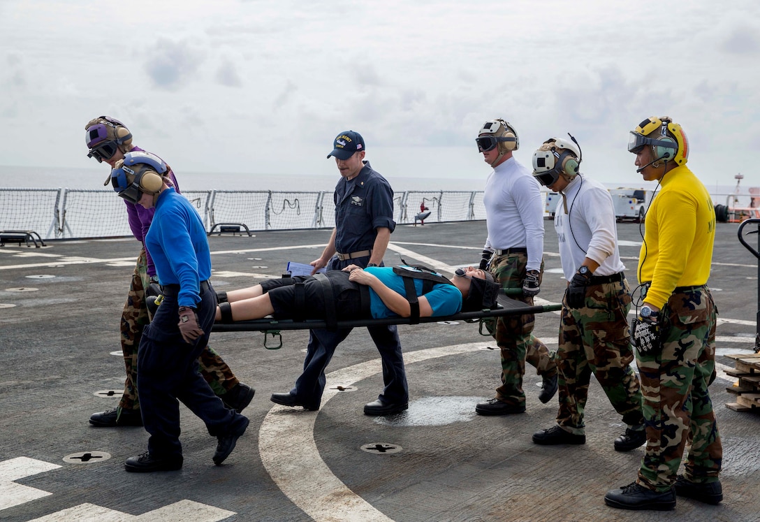 U.S. Navy crew members conduct a mass casualty drill on board the ...