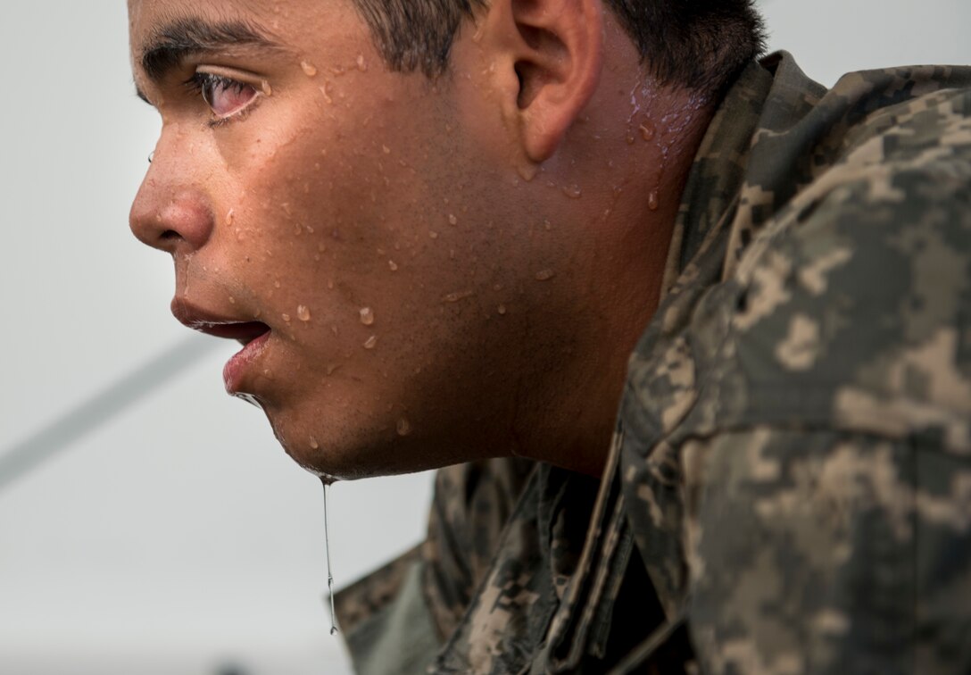 A soldier takes a breather while swimming 25 meters with a ruck sack ...