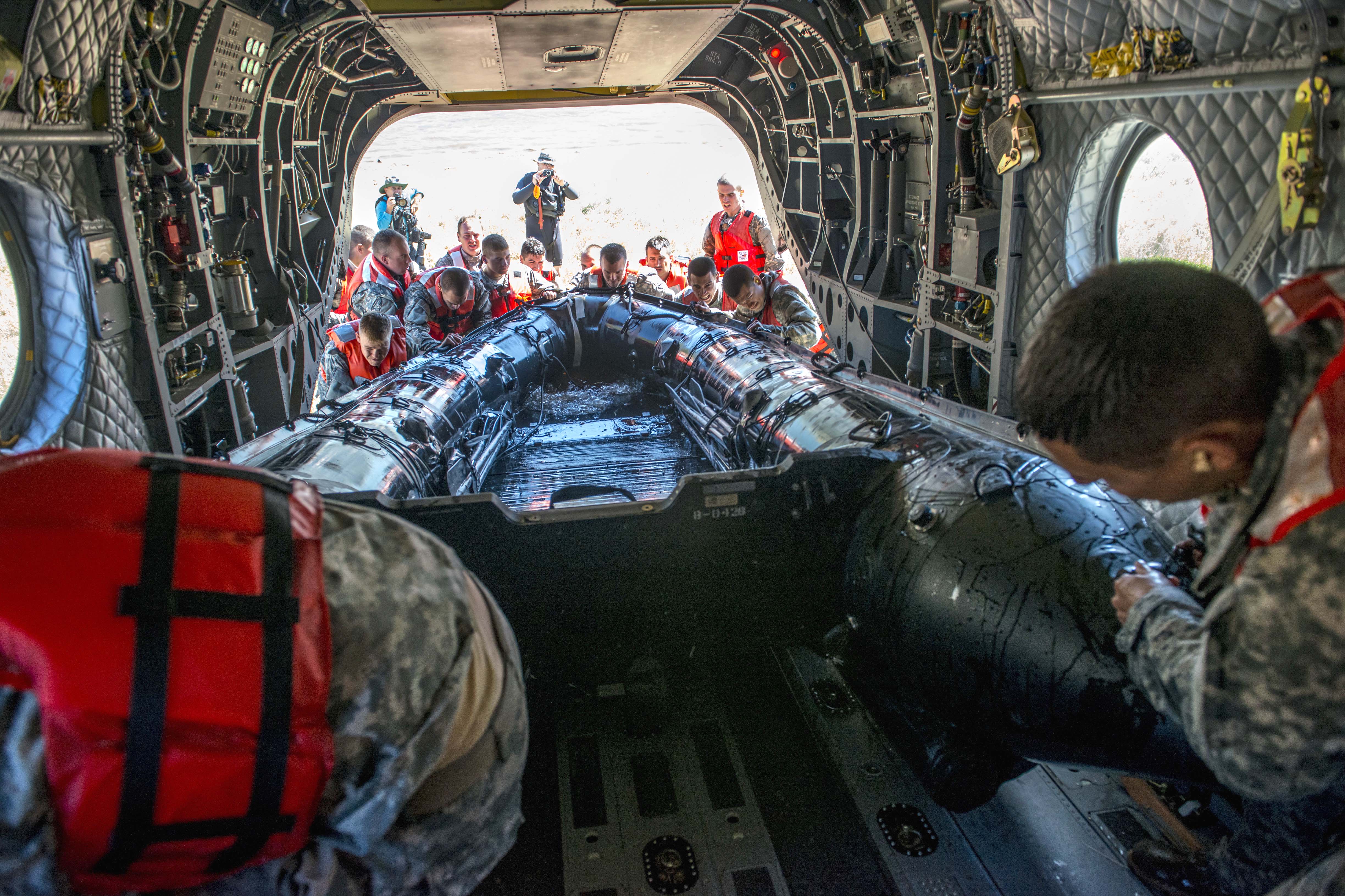 Soldiers push a Zodiac boat onto a CH-47 Chinook helicopter at Lopez ...