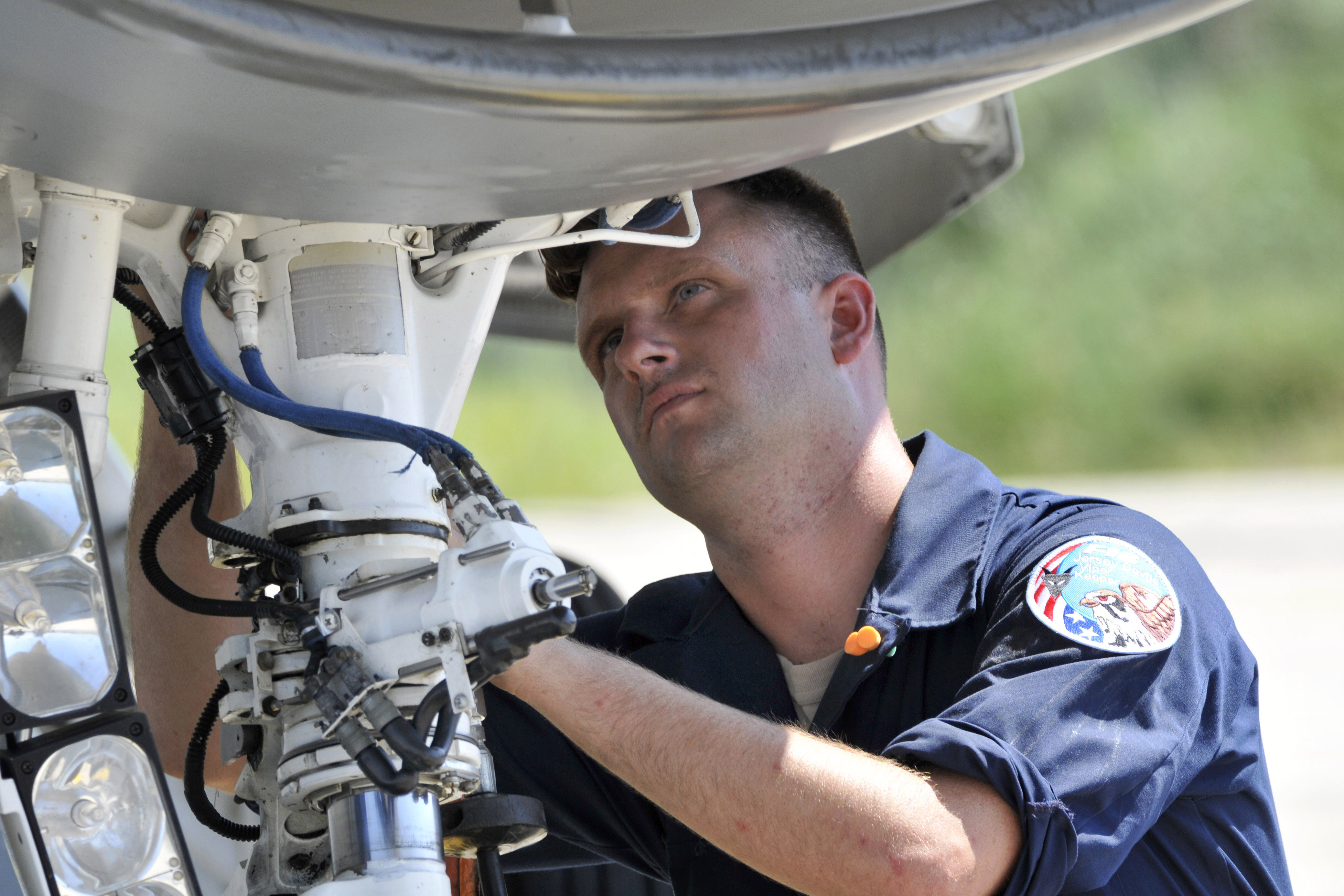 U.S. Air Force Senior Airman Christian Mirande fixes the struts and ...