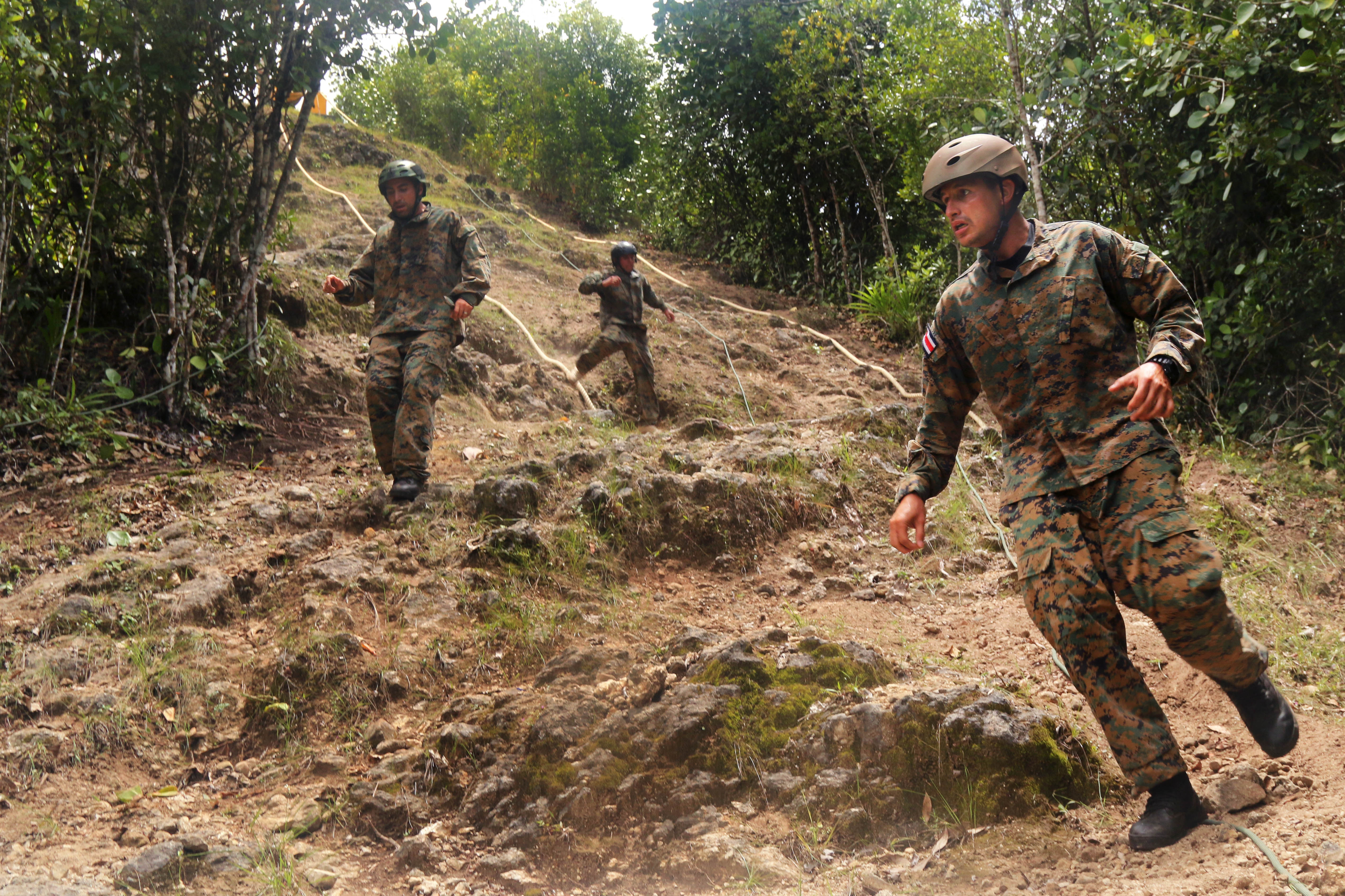 Costa Rican special operations team members run down a hill during the ...