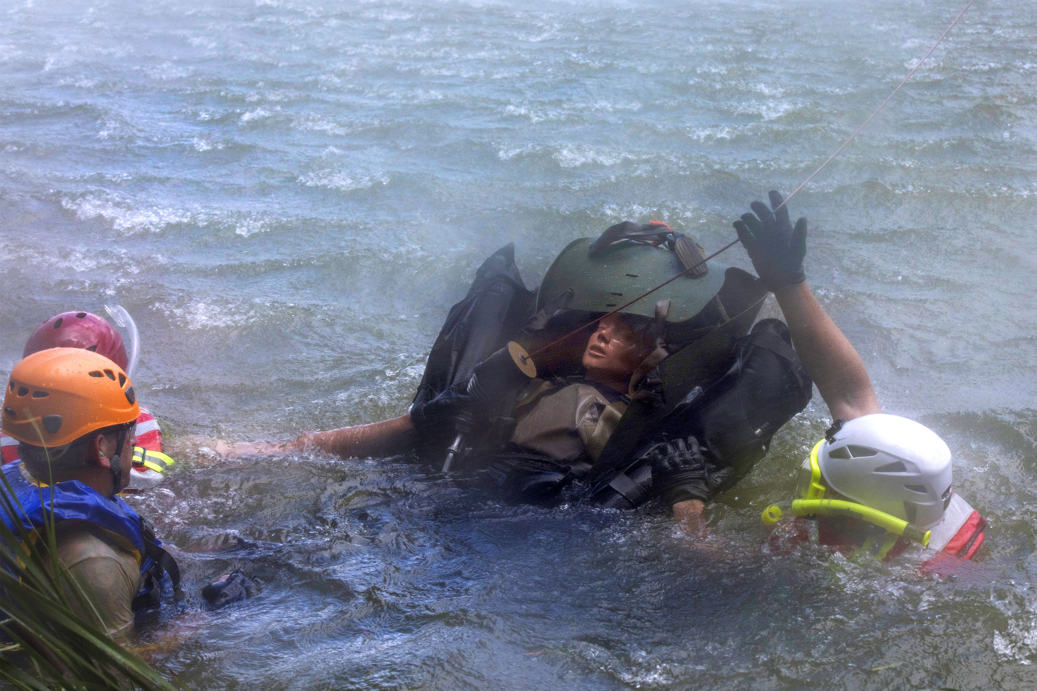 Soldiers battle rotor wash from a UH-60M Black Hawk helicopter while ...