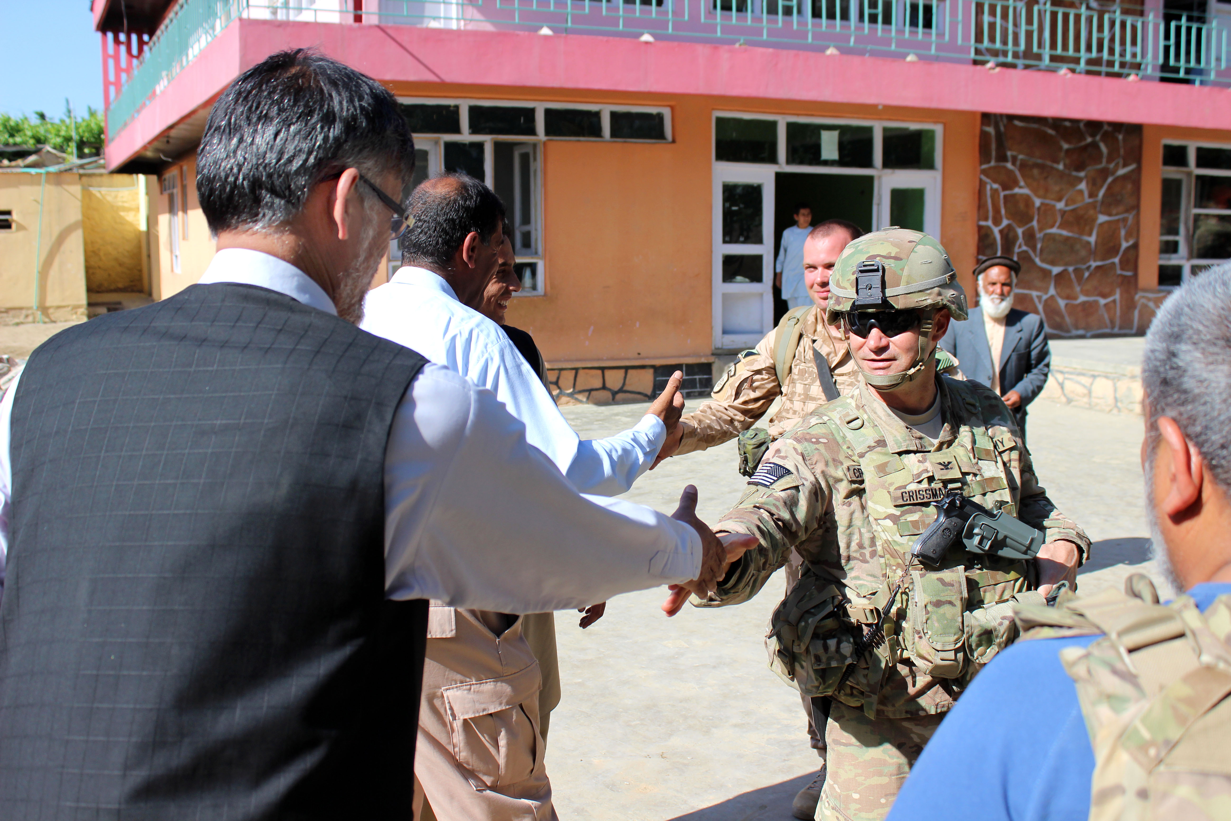 U.S. Army Col. Douglas C. Crissman shakes hands with Afghan officials ...