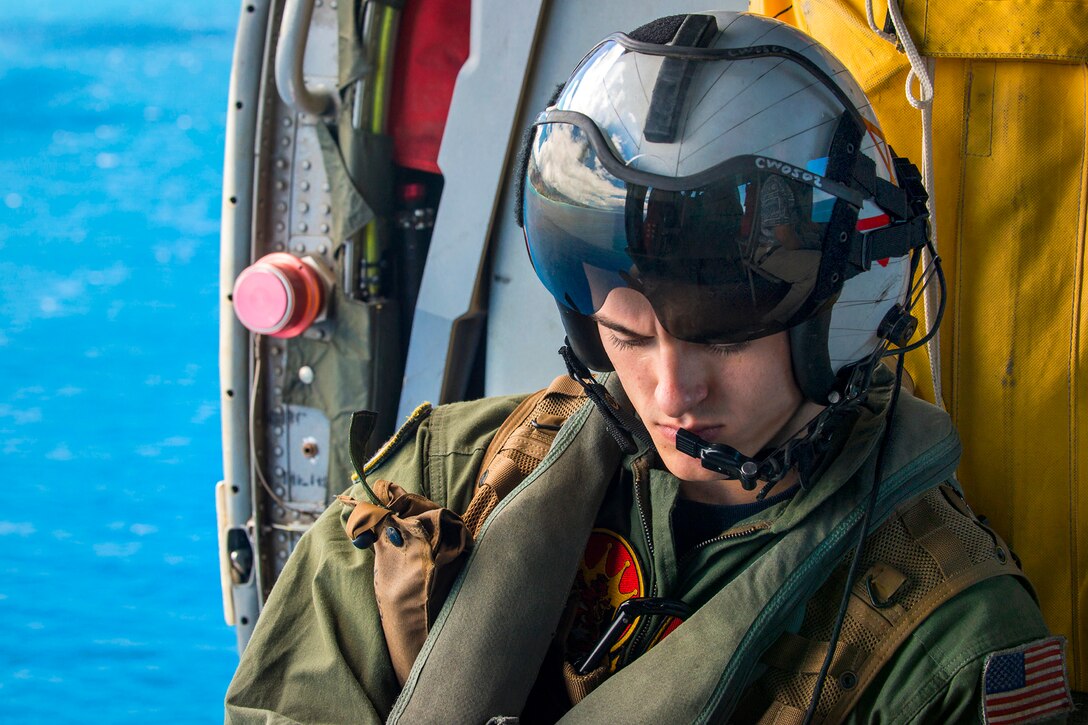 A U.S. sailor flies in an MH-60S Seahawk helicopter assigned to the ...