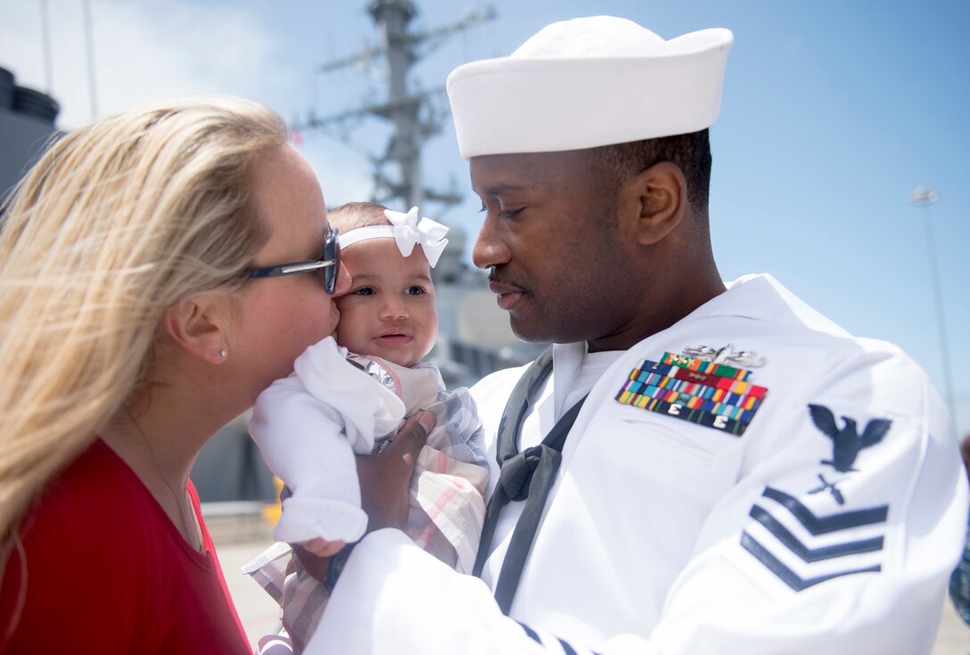 Navy Petty Officer 1st Class Herbert Bushner holds his newborn daughter ...