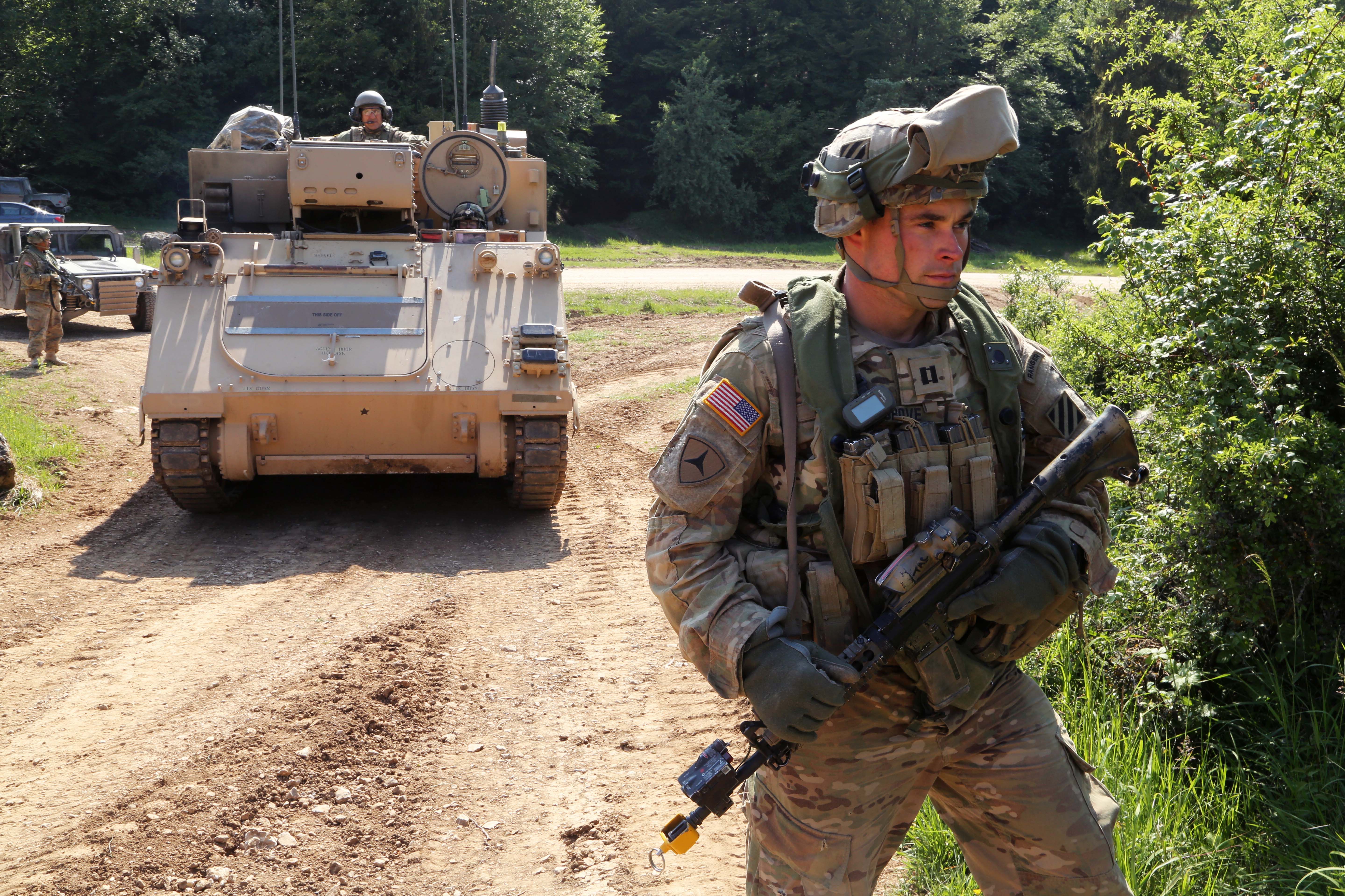U.S Army Cpt. Matthew Grove ground guides an M1068A3 Standard Integrated Command Post System ...