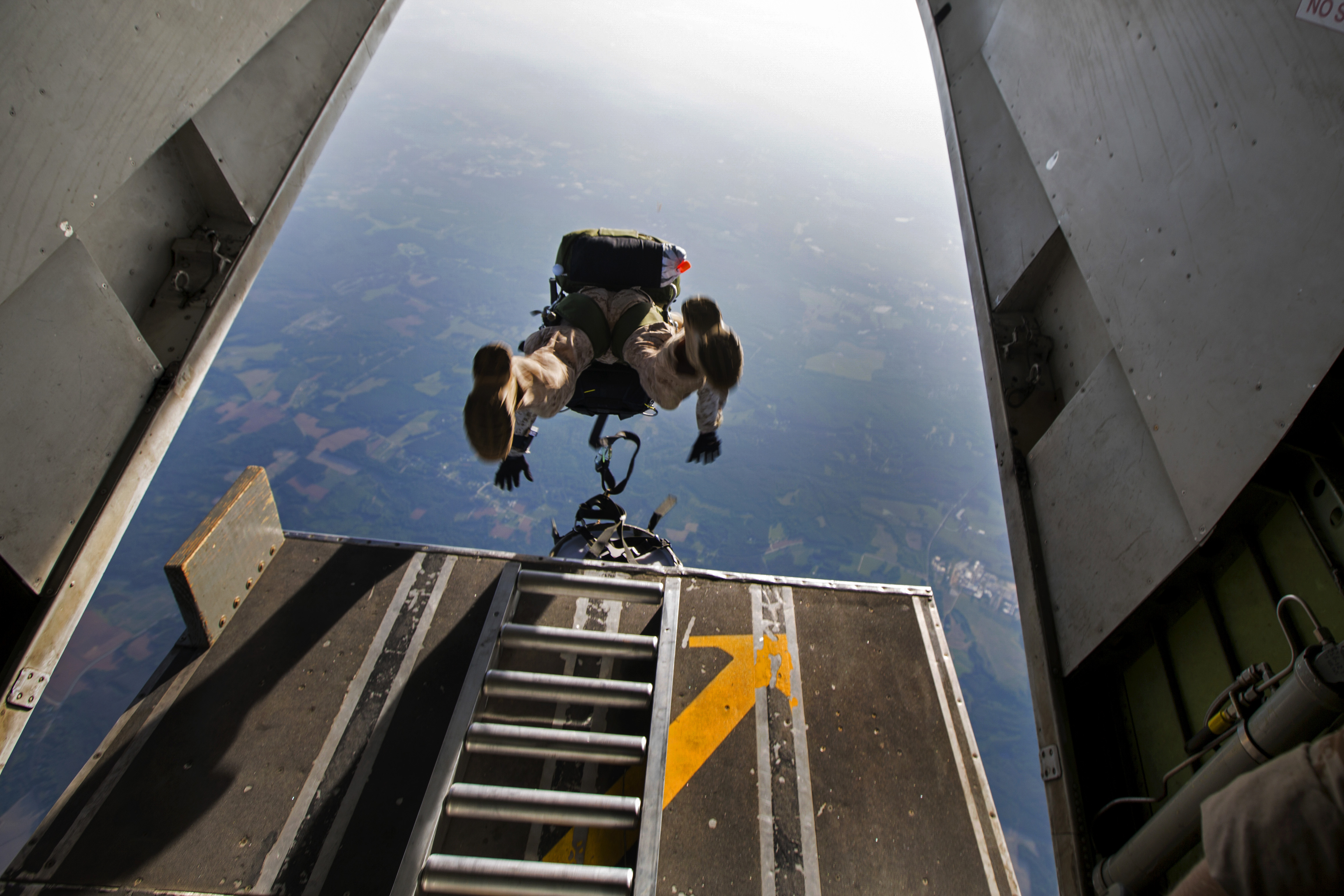 A Marine conducts a high-altitude, high-opening jump while attached to ...