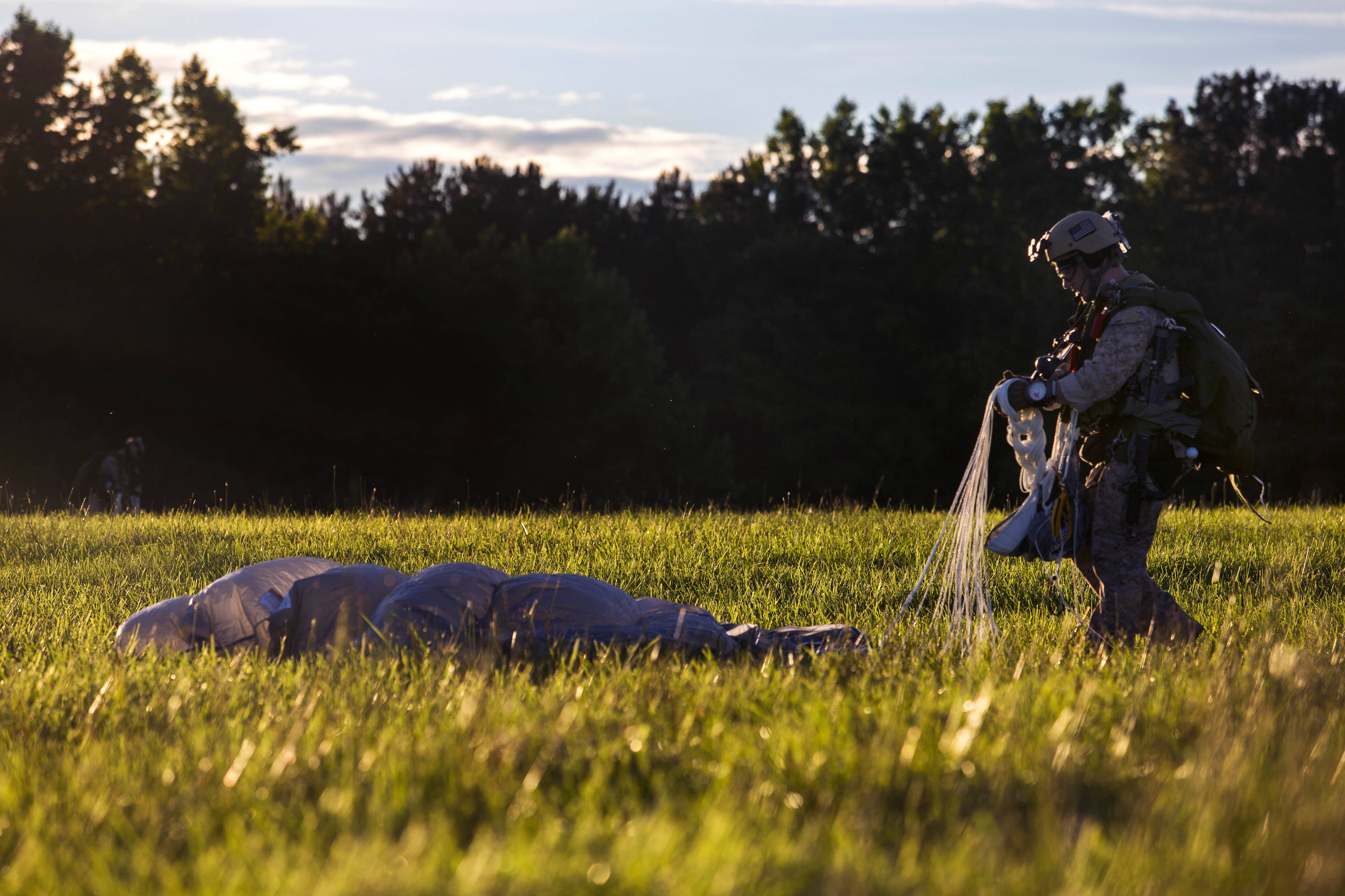 A Marine recovers his parachute after conducting a high-altitude, high ...