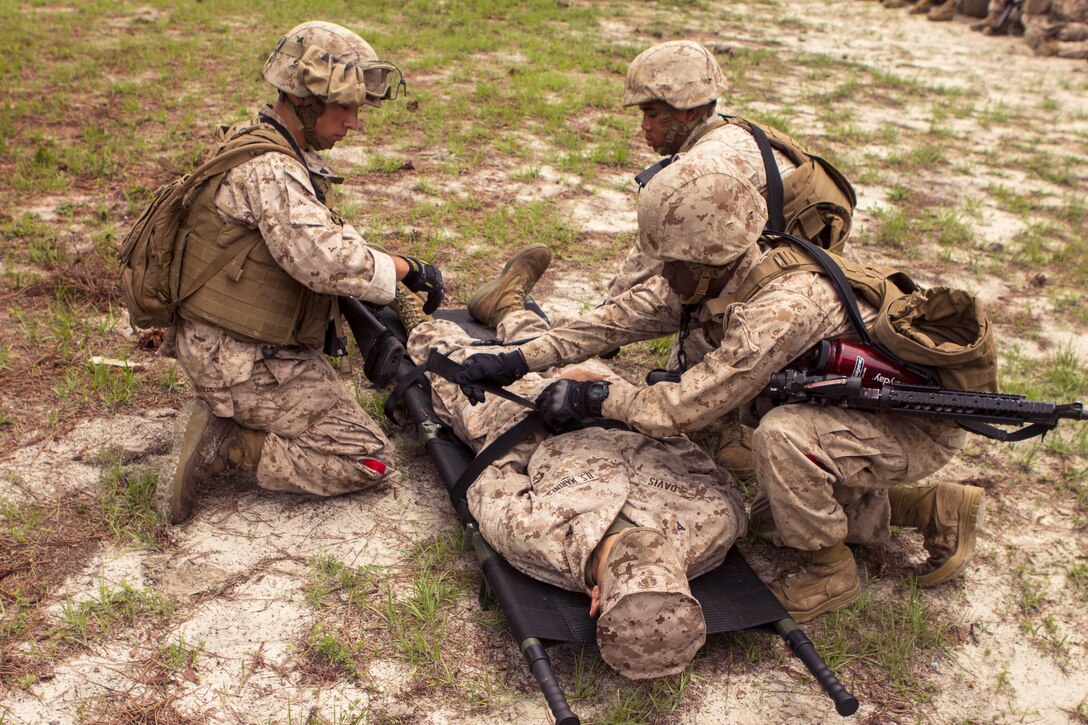 Marines strap a simulated casualty onto a litter during a mass casualty ...