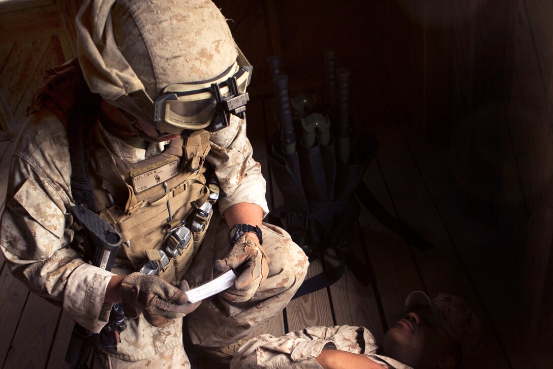 Marine Corps Lance Cpl. Dustin Mason assesses a simulated casualty ...