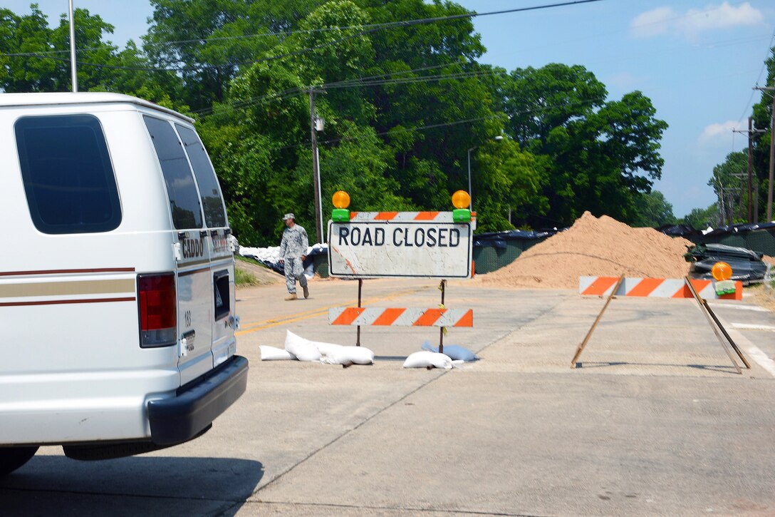 Soldiers close off a road after constructing a temporary levee in ...