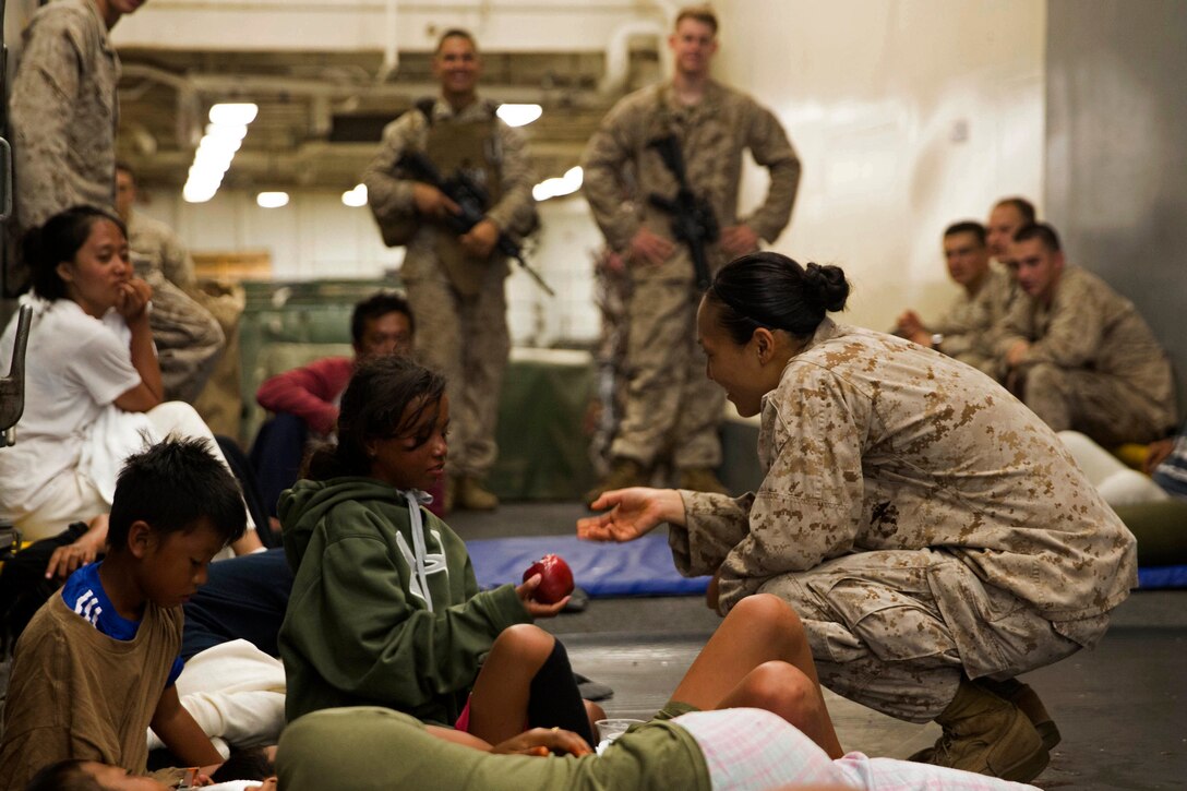 U.S. Marine Cpl. Jennifer Ko gives an apple to a distressed mariner ...