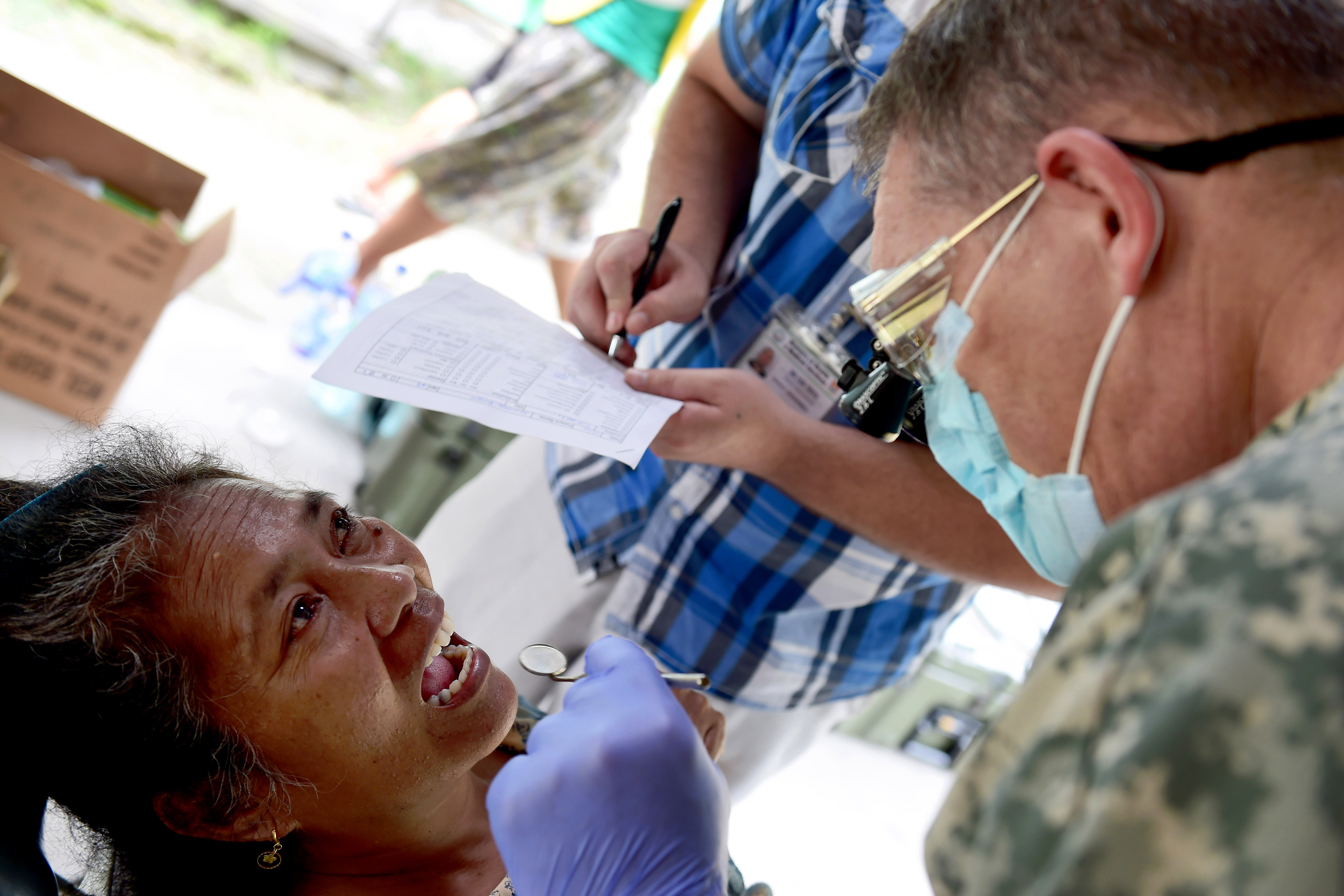 U.S. Army Col. Anthony Thomas examines a patient during a Pacific ...
