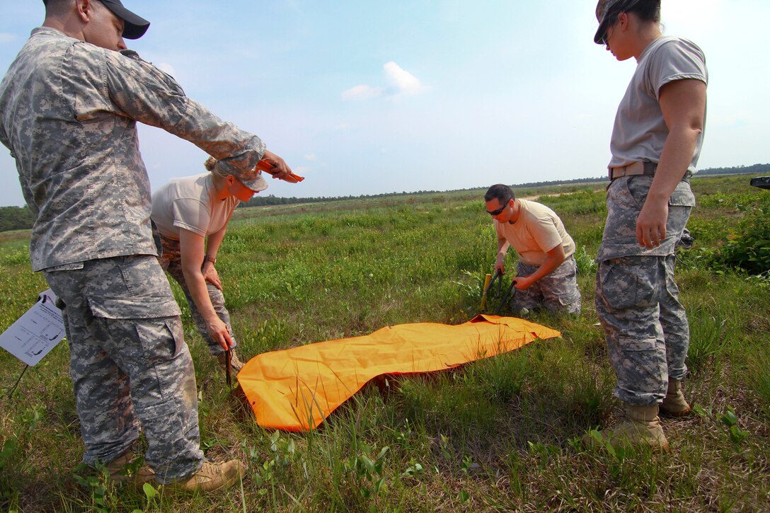 Army Reserve soldiers lay out signal panel markers before an airborne ...