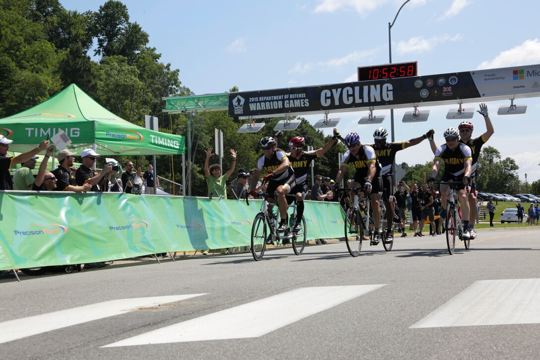 U.S. Army athletes cross the finish line during a tandem cycling ...