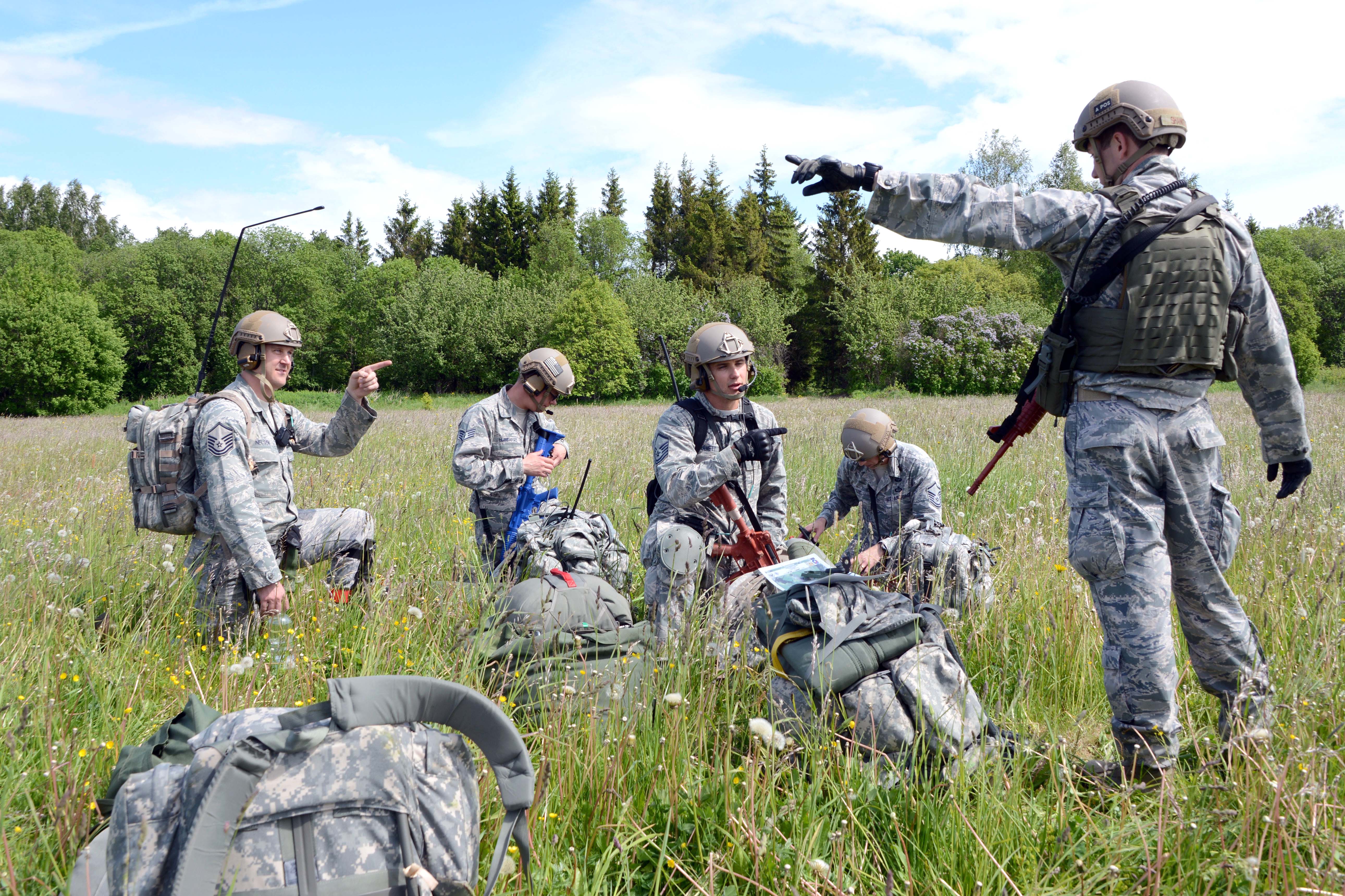U.S. airmen gather their chutes and gear before heading to a rally ...