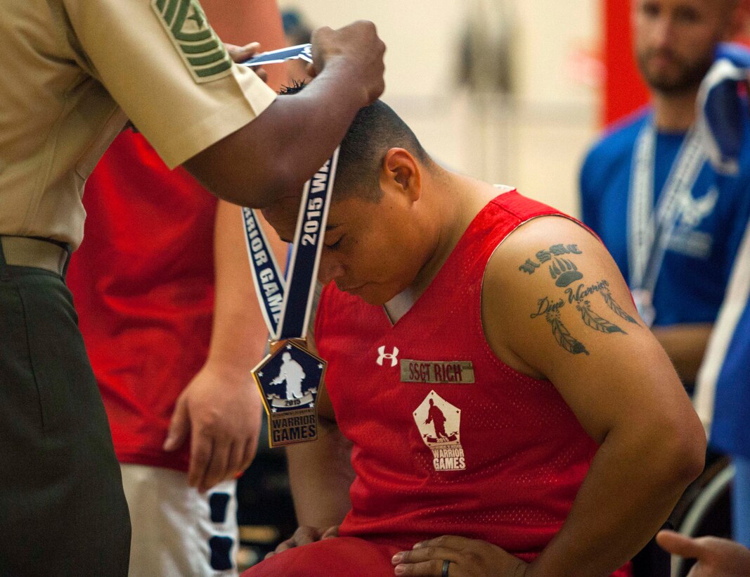 U.S. Marine Corps veteran Marcus Chischilly receives a gold medal after ...