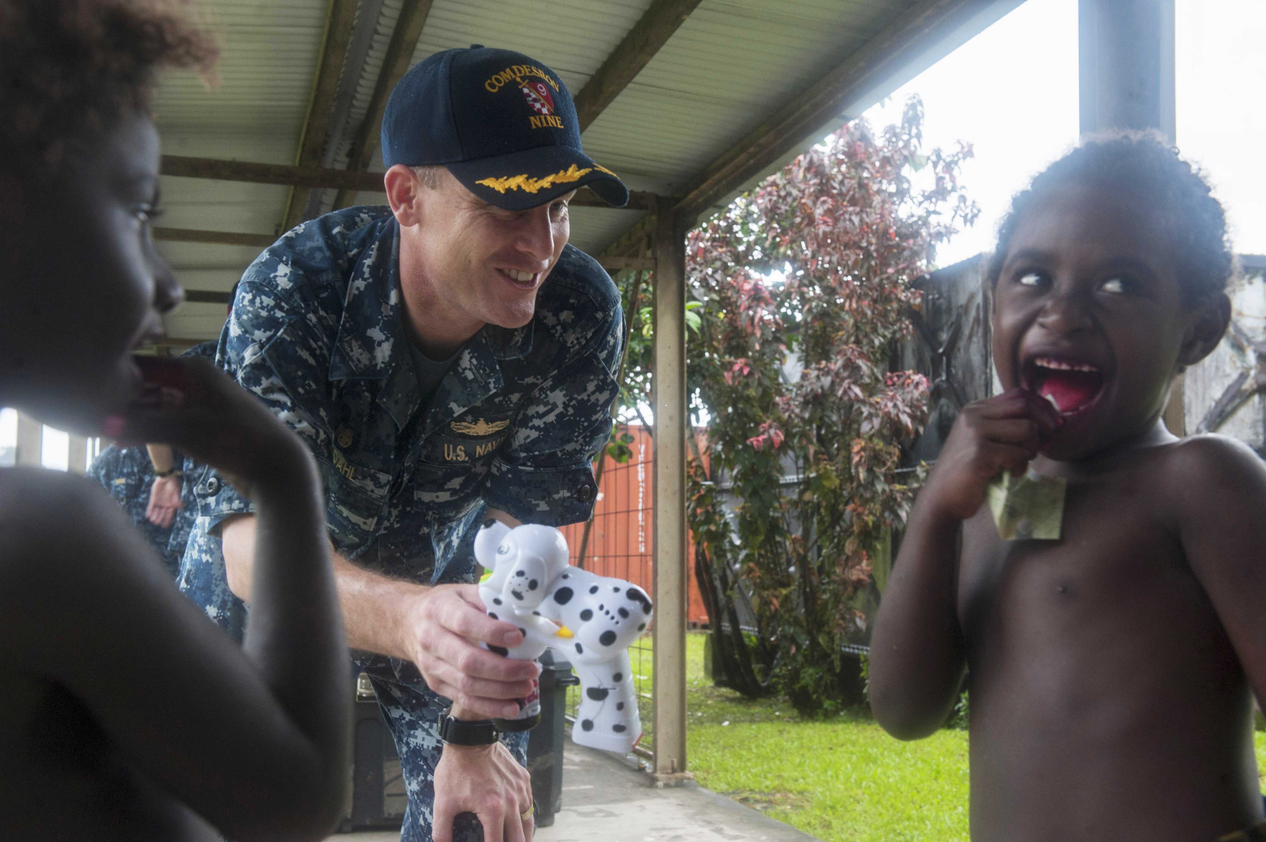 U.S. Navy Capt. Chris Engdahl plays with local children at a community ...