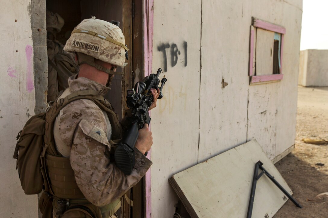 U.S. Marine Corps Lance Cpl. Aaron Anderson prepares to breach a door ...