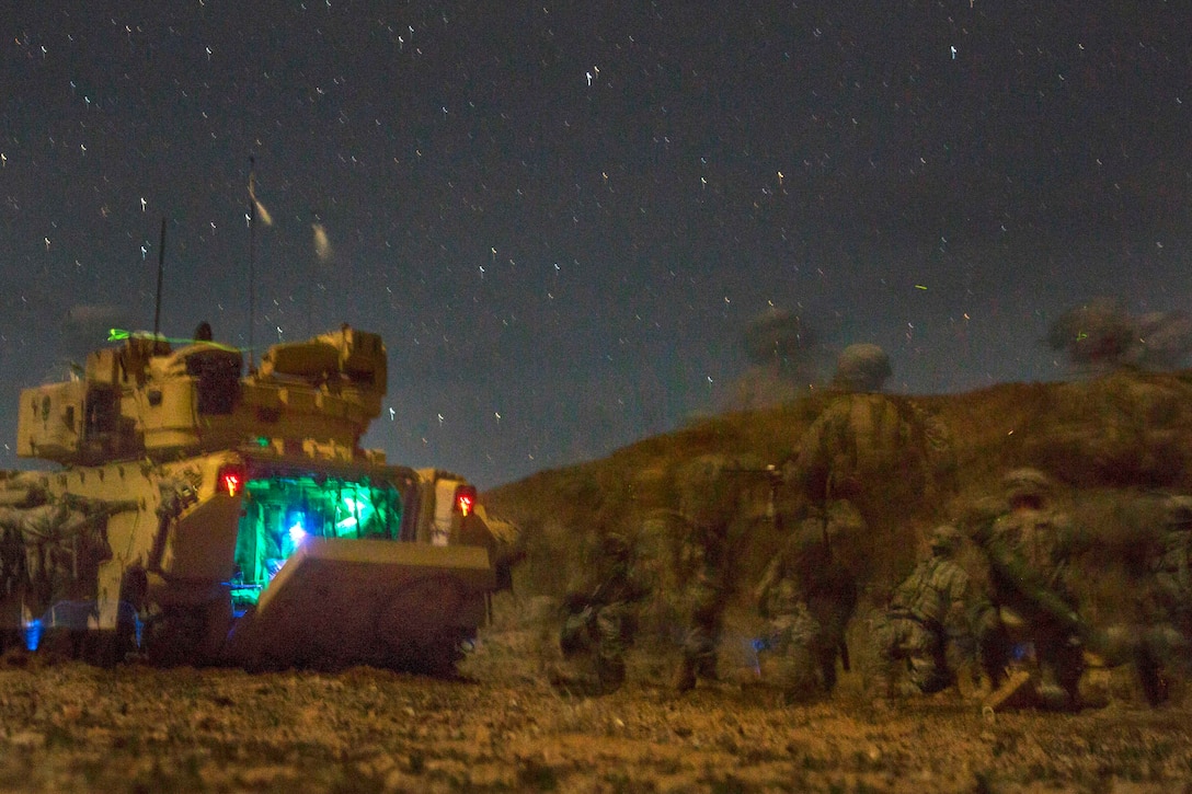 Soldiers dismount from an M2 Bradley infantry fighting vehicle outside ...