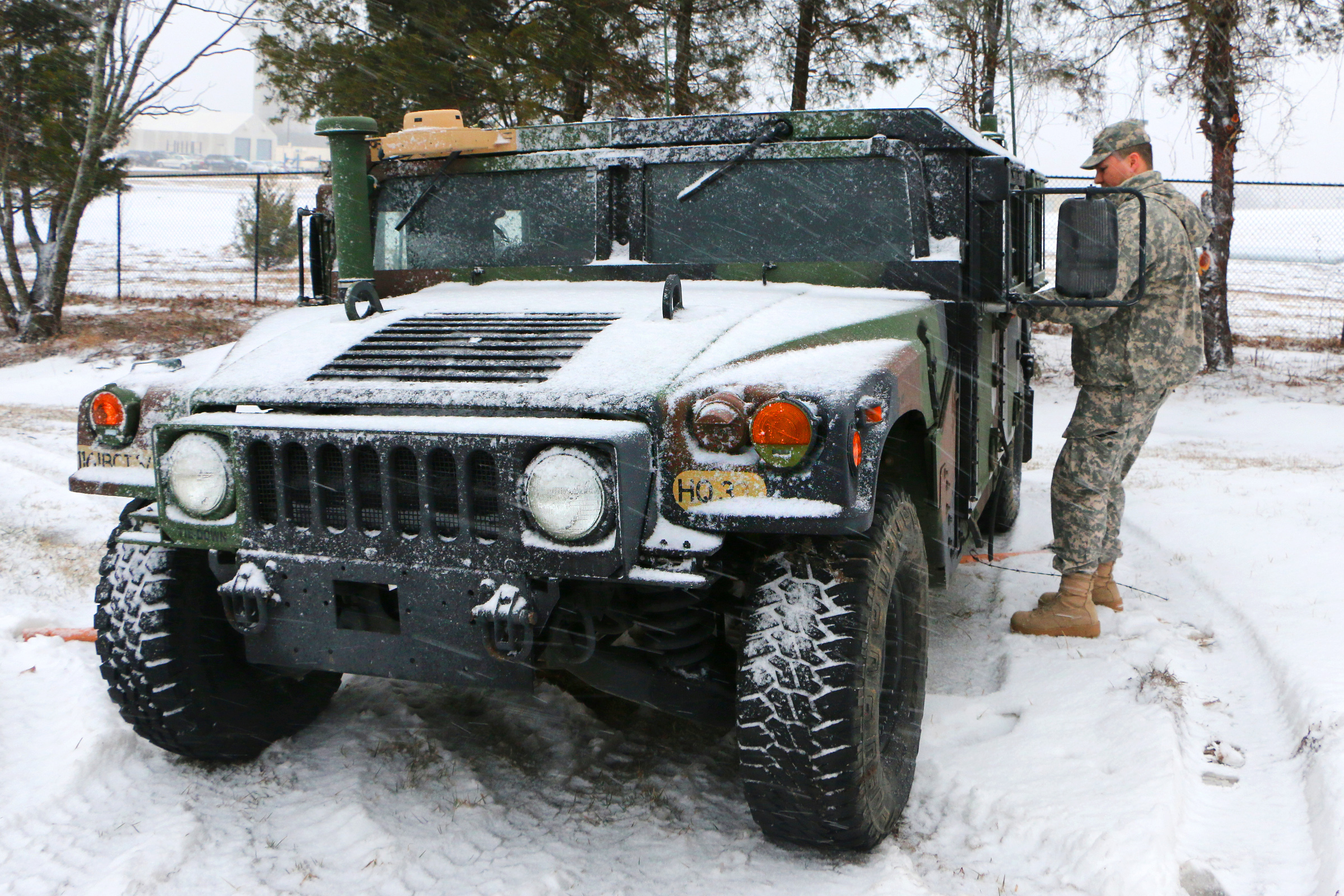 A soldier prepares his Humvee for possible winter storm response ...