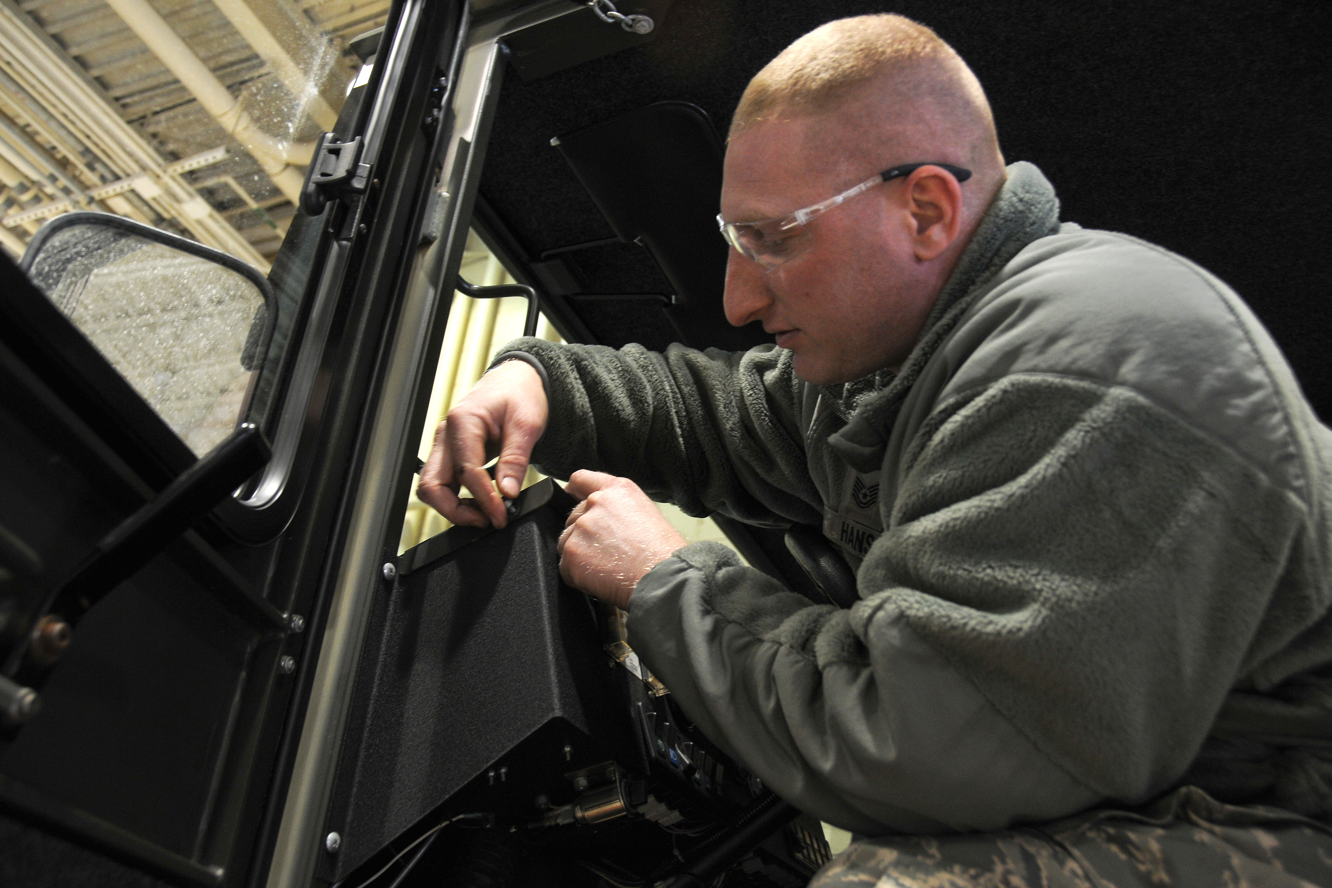 Air Force Tech. Sgt. David Hansen fastens a panel on an MB-4 aircraft ...