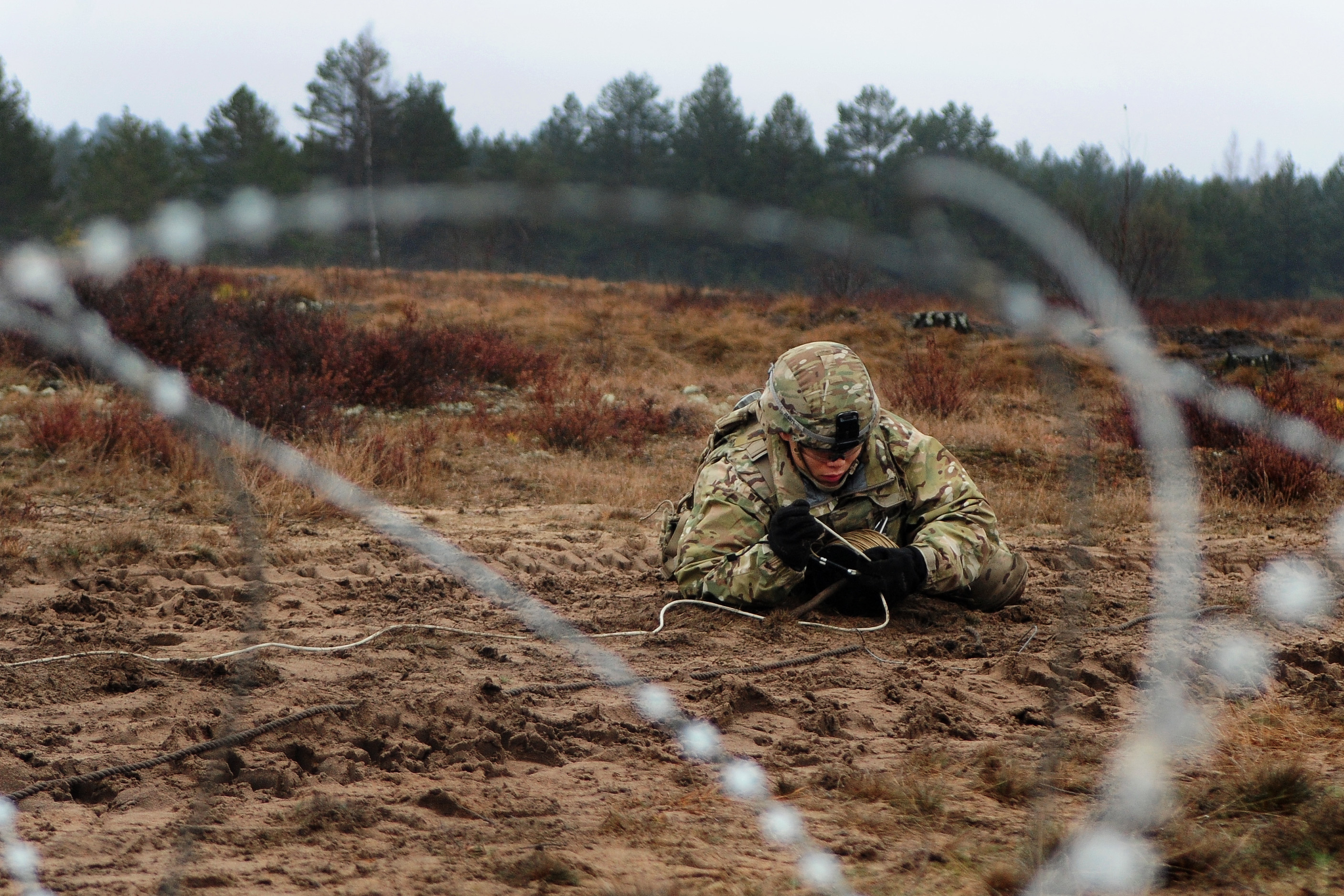 U.S. Army Spc. Jake P. Tran prepares an explosive charge to breach a ...
