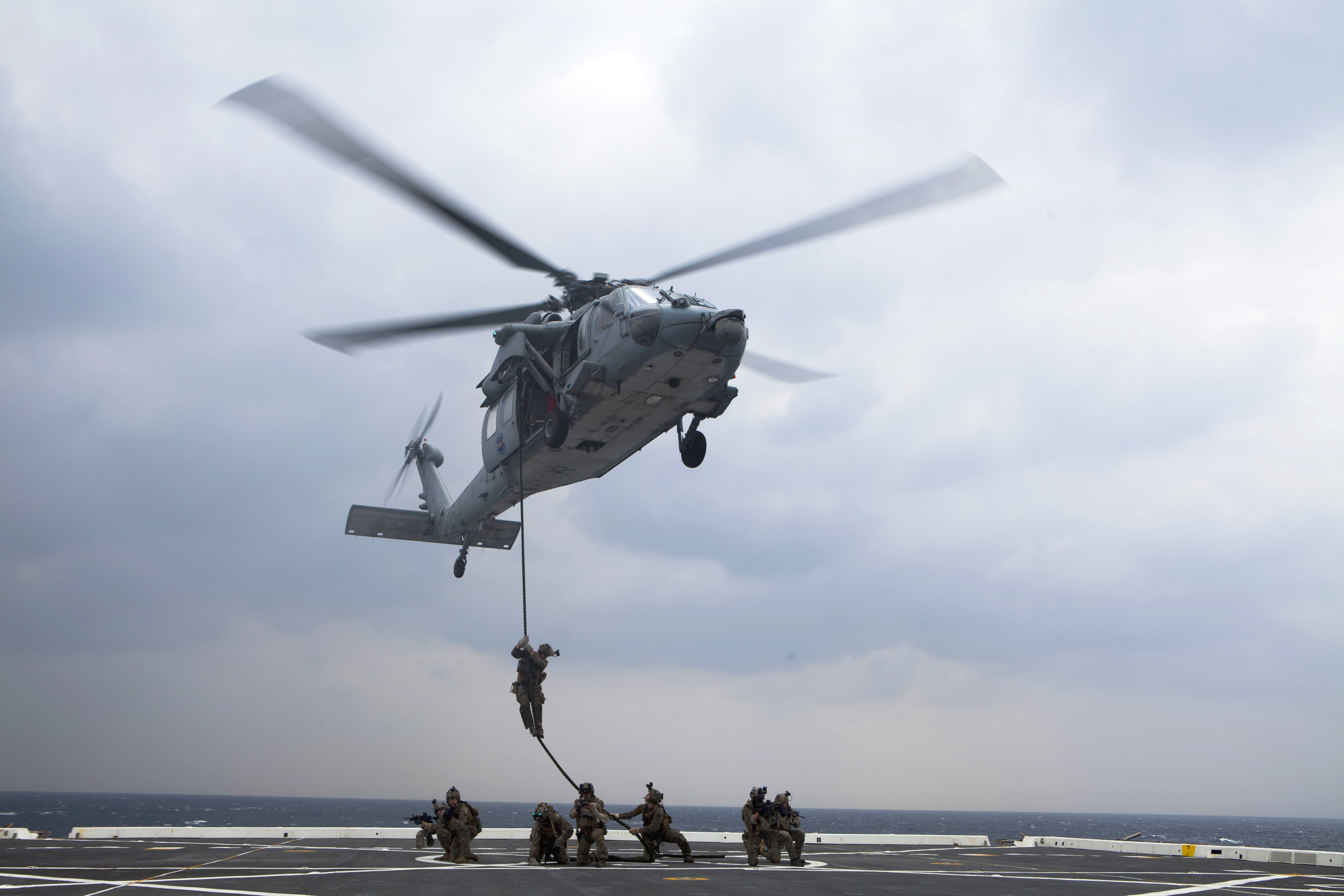 U.S. Marines fast rope from an MH-60s Seahawk helicopter to the flight ...