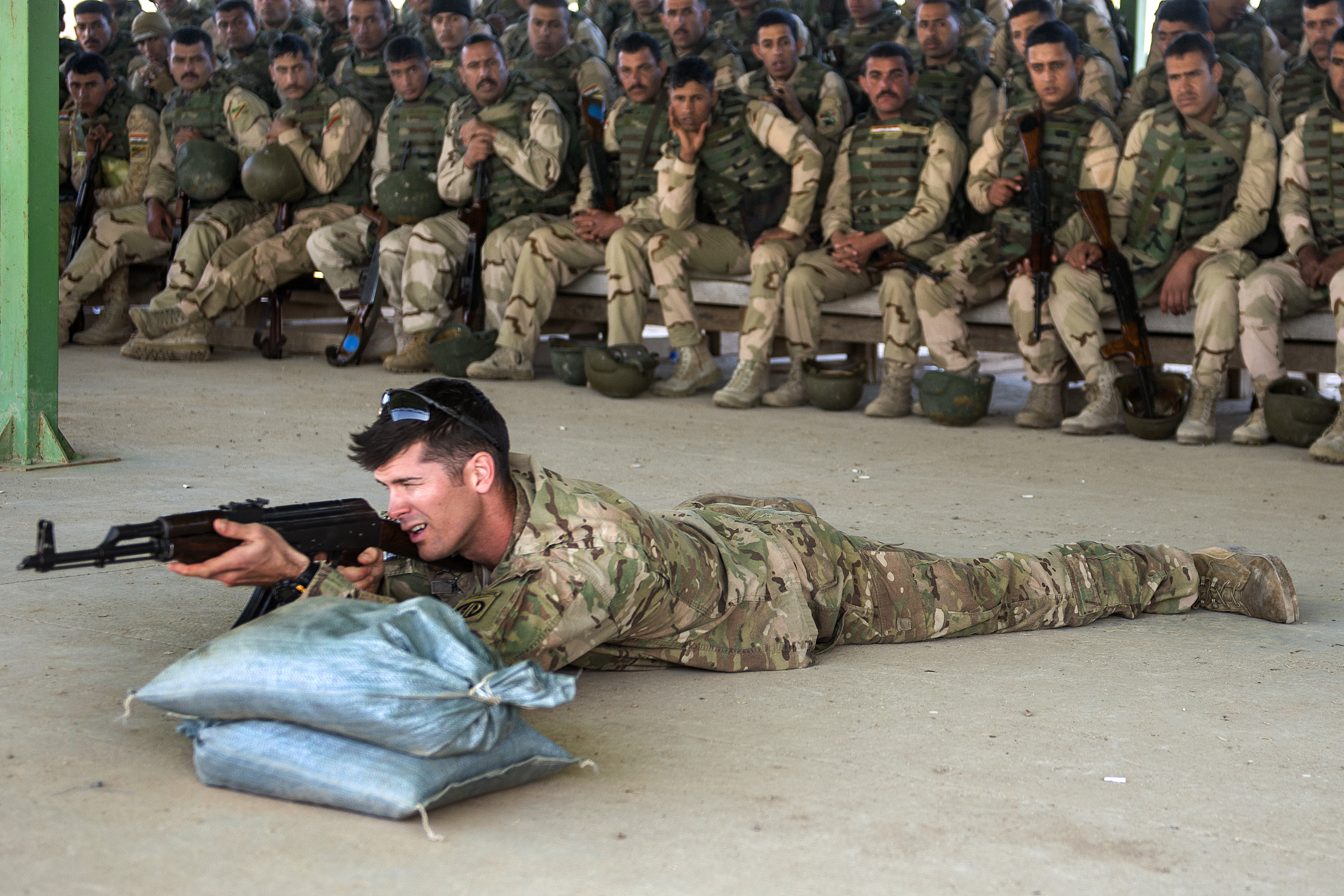 U.S. Army Staff Sgt. William Hacker, foreground, demonstrates rifle ...