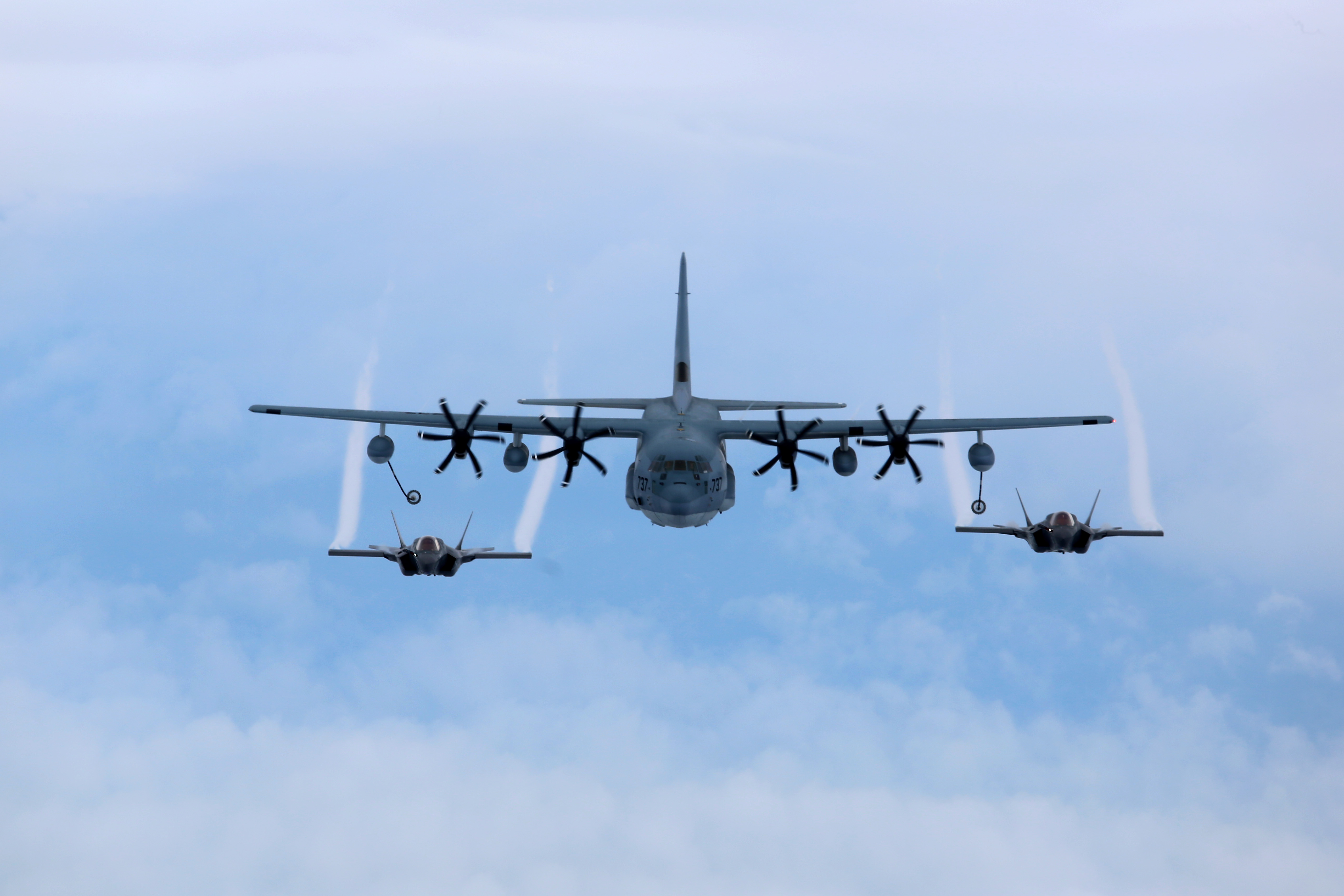 A U.S. Marine Corps KC-130 aircraft flies with two F-35B Lightning II ...