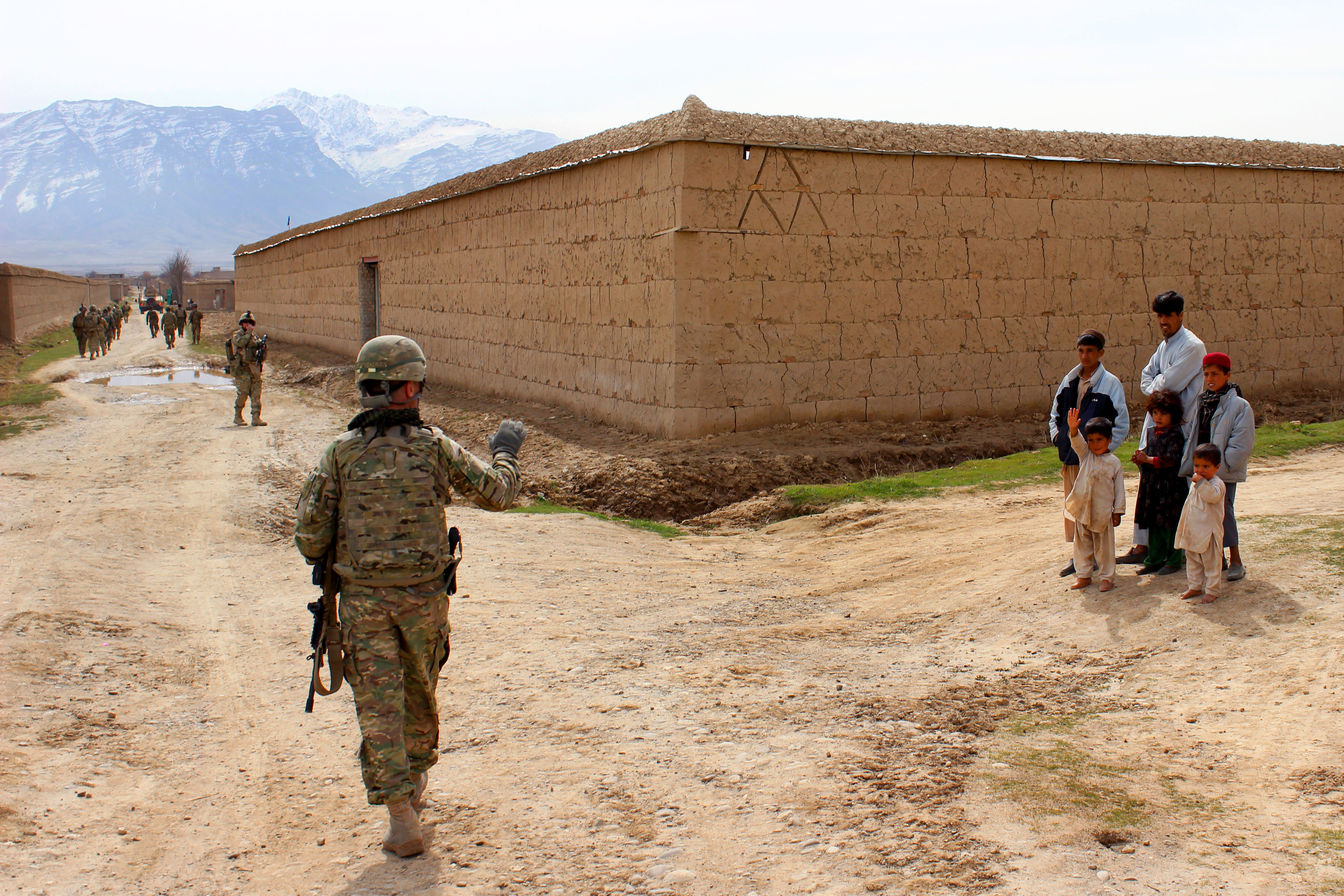 A Georgian soldier waves hello to local villagers while other coalition ...