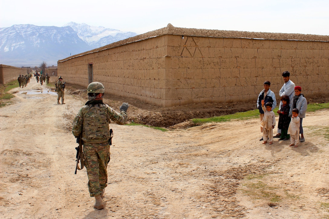 A Georgian soldier waves hello to local villagers while other coalition ...