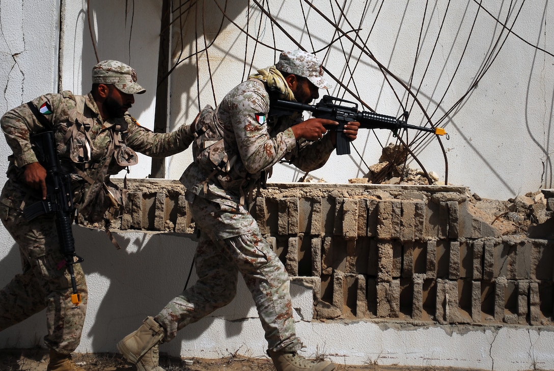 Two Kuwaiti soldiers move toward an objective during a simulated urban ...