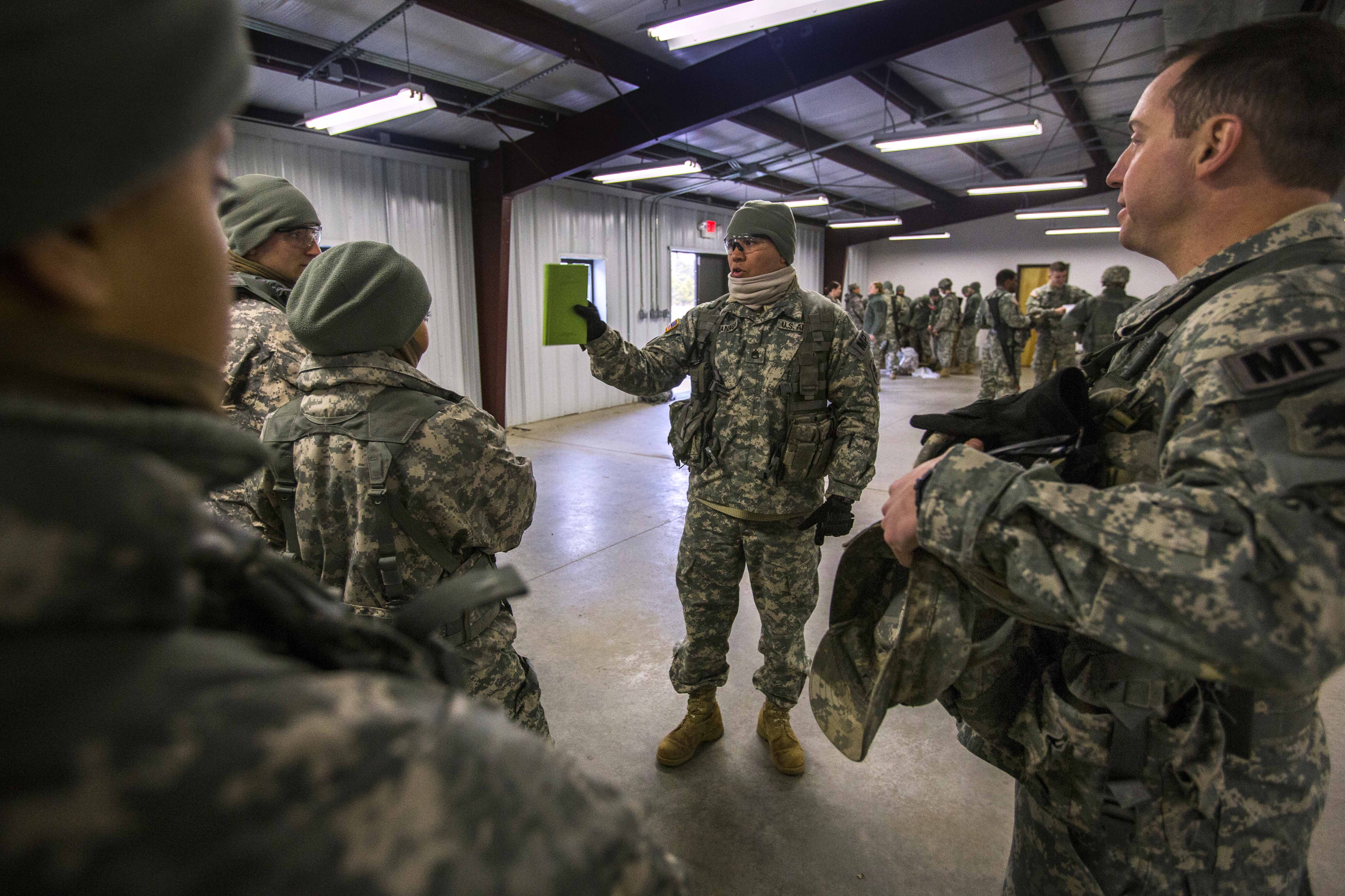 Army Staff Sgt. Manuel Larranaga Jr., center, briefs soldiers before ...