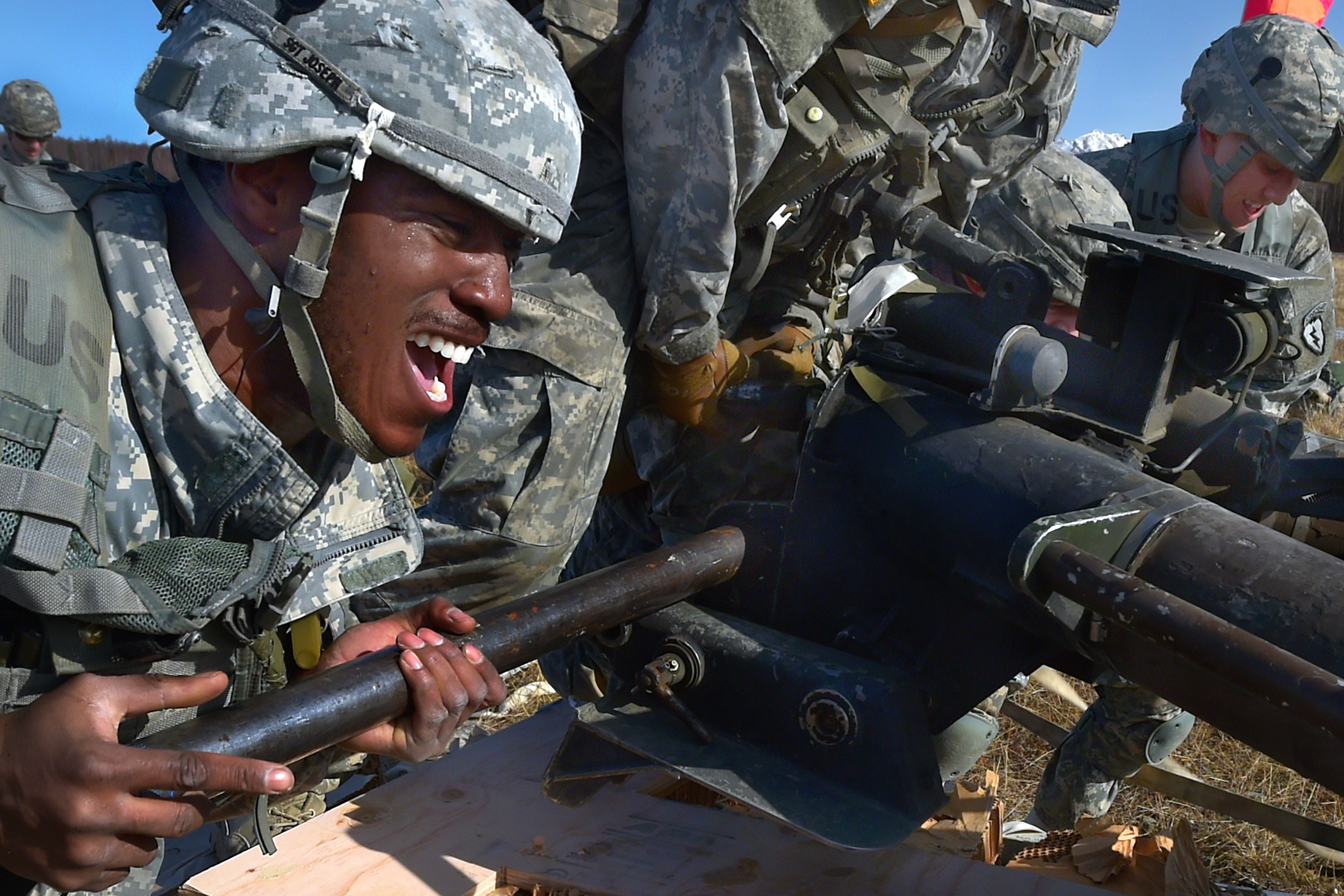 Army Sgt. Phillip Joseph pushes a 105-mm howitzer off a pallet with ...