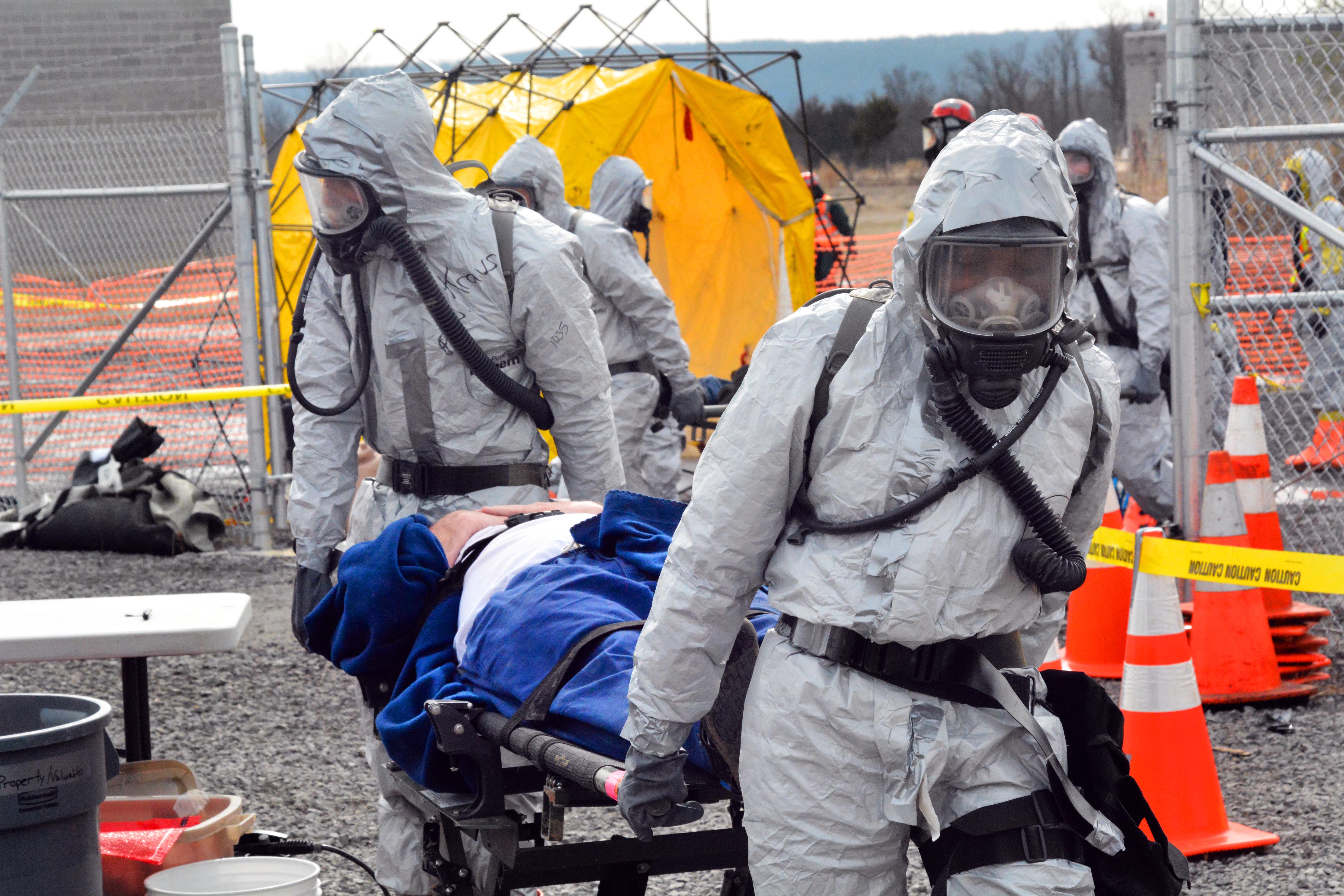 Soldiers and airmen move a simulated patient on a wheeled stretcher ...