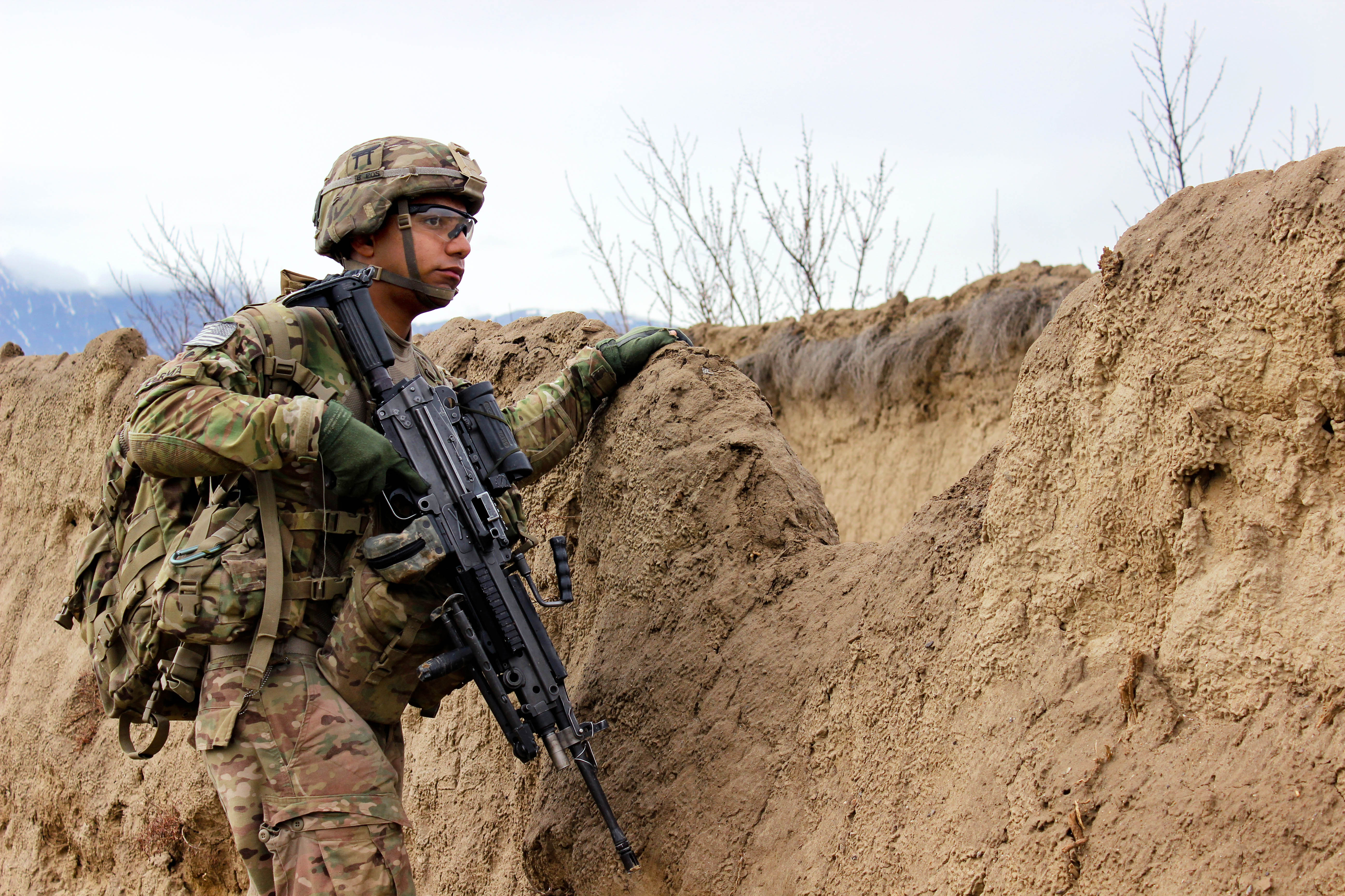 A U.S. soldier provides security from behind a dirt wall while other ...