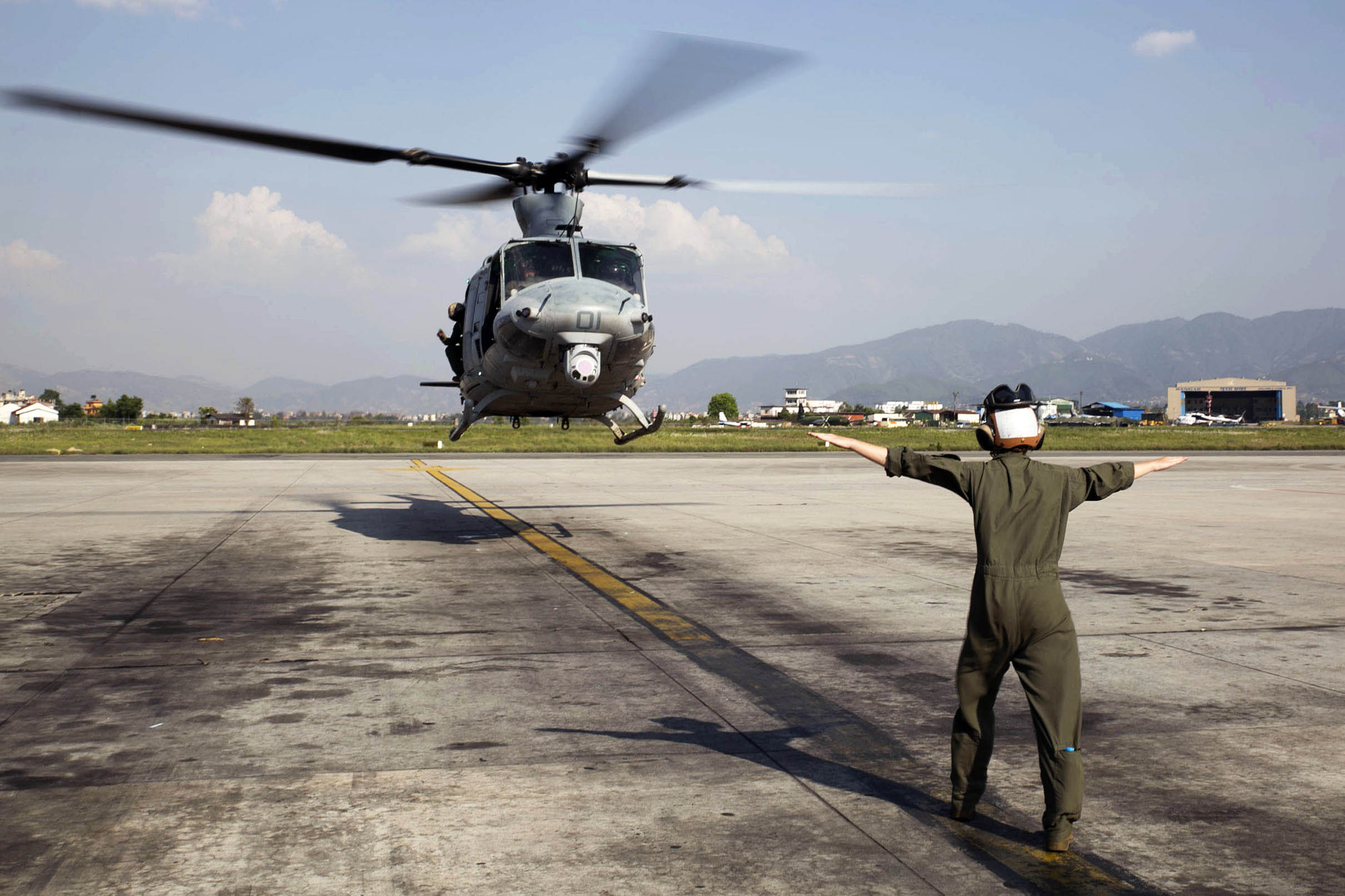 Marine Cpl. Mackenzie Higgins guides a Marine UH-1 helicopter at the ...