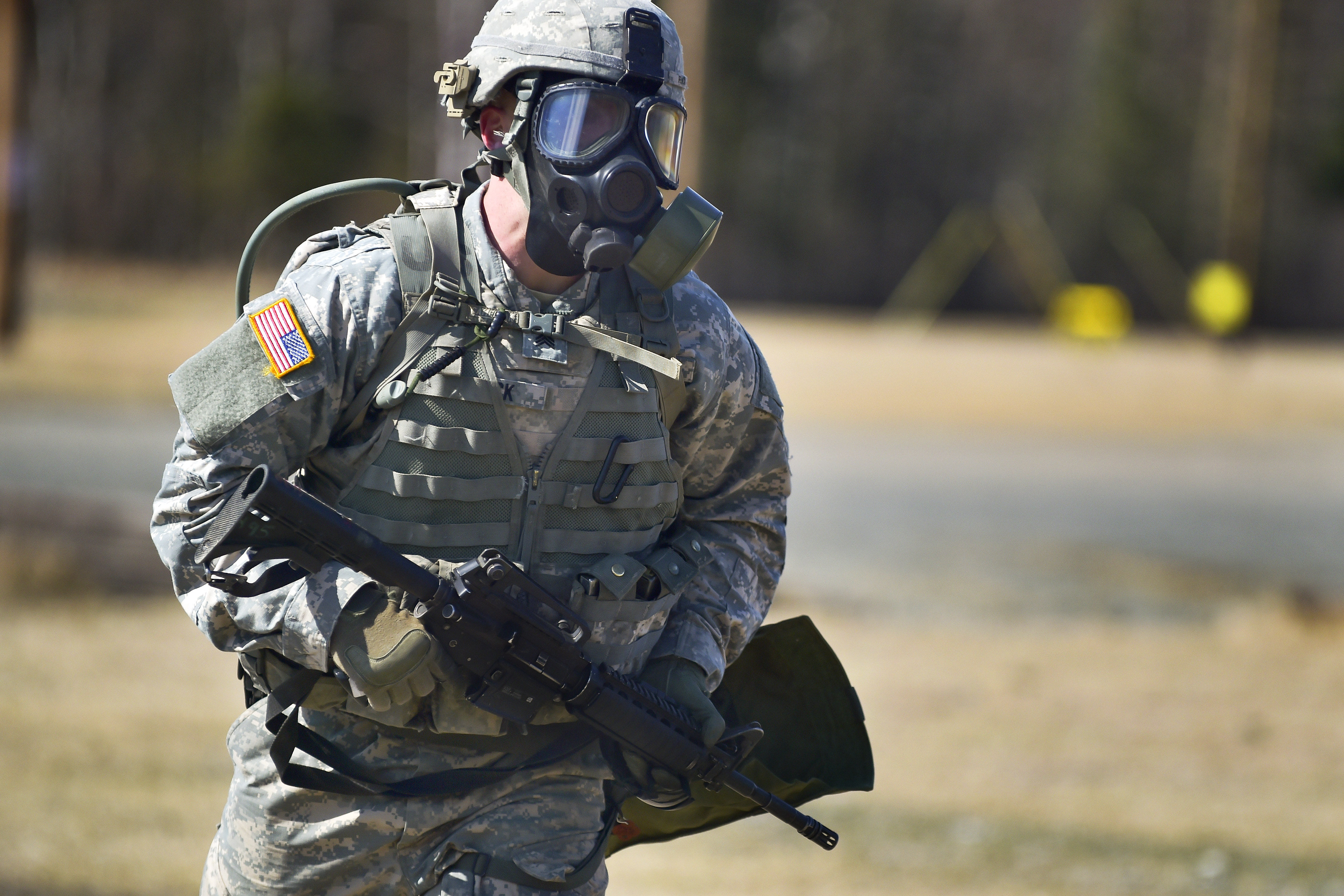 Army Sgt. Ted Flick runs in a protective mask during the Best Warrior ...