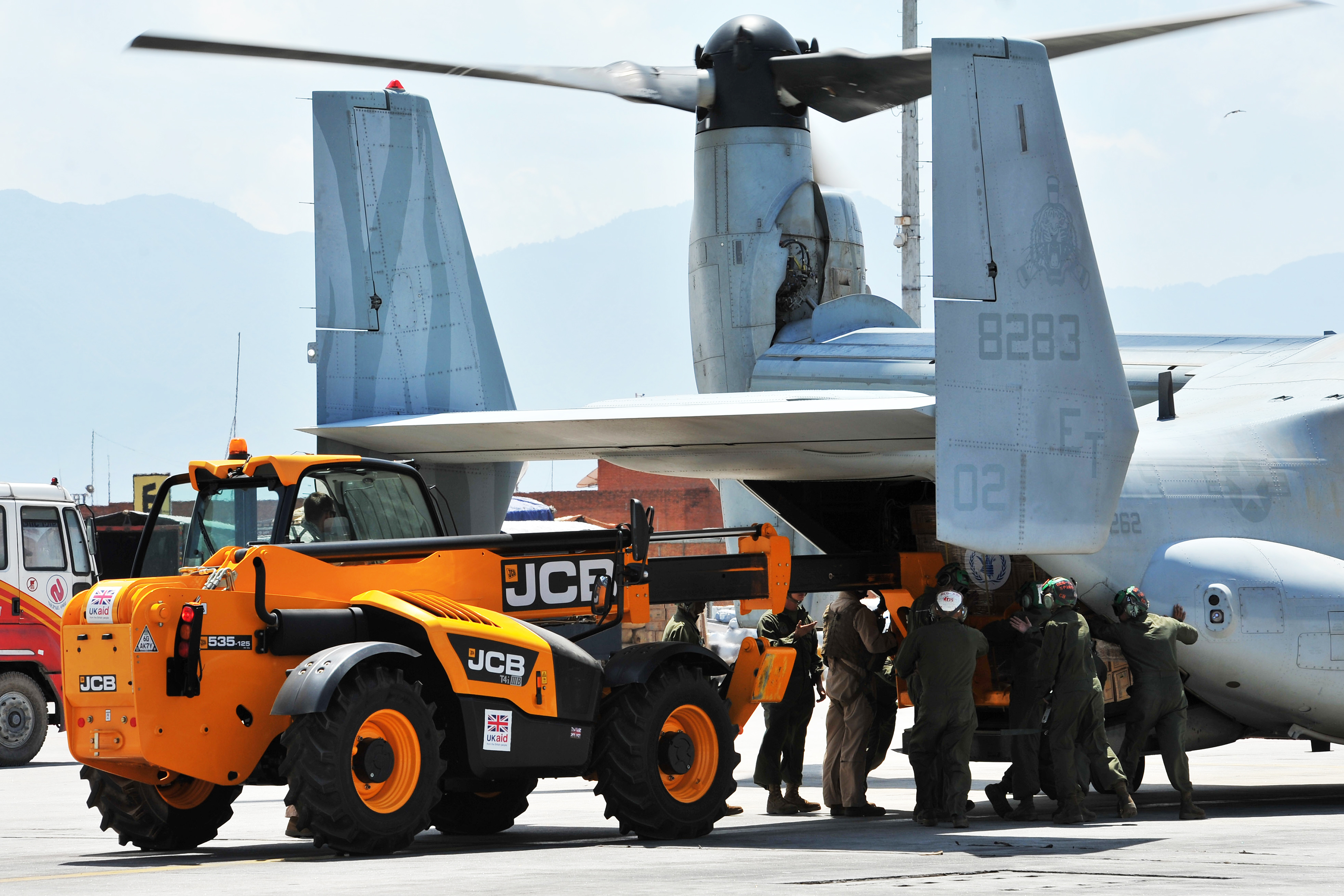 Air Force Staff Sgt. Josh Foley loads relief supplies onto a Marine MV ...
