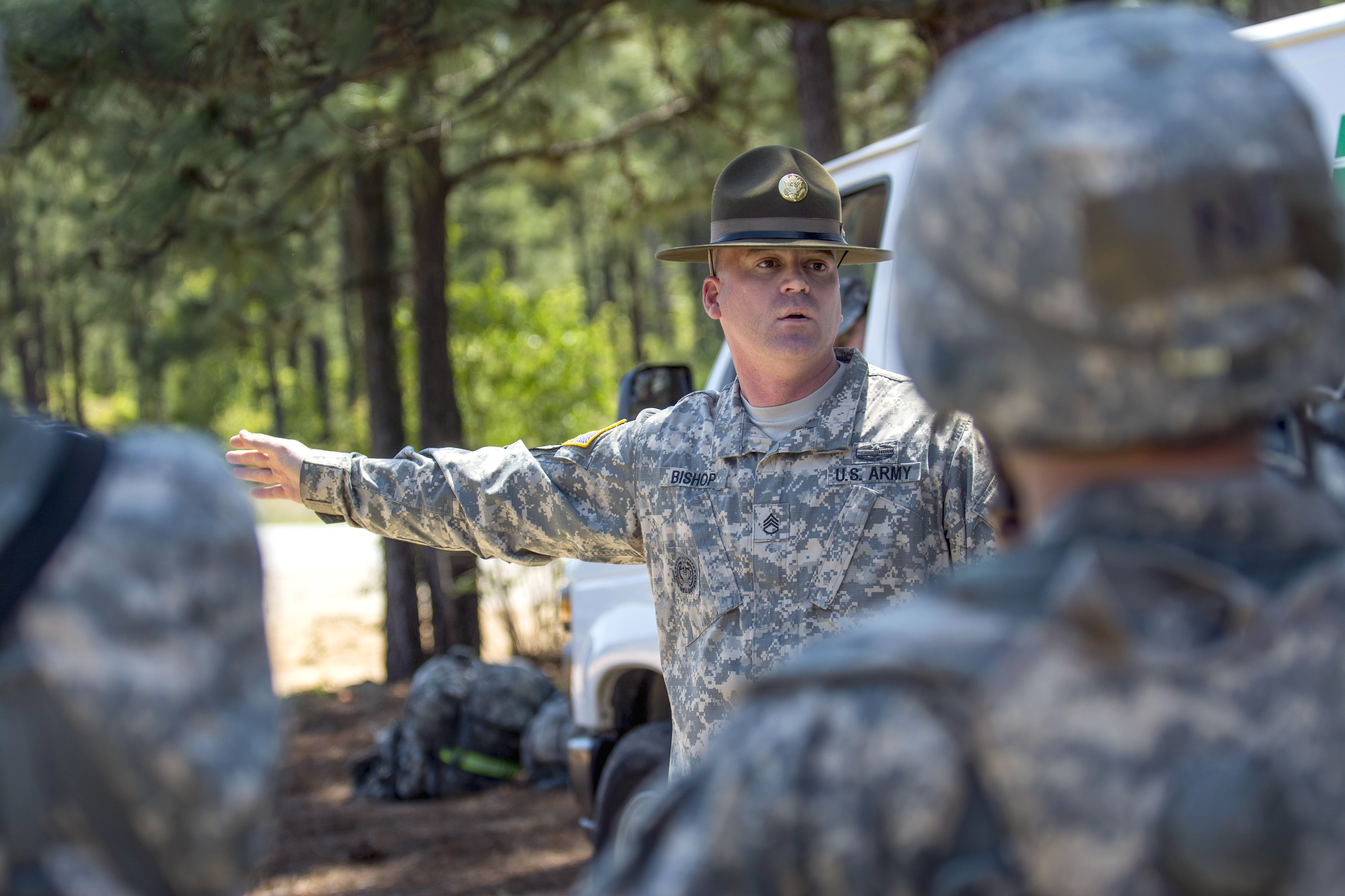 Army Staff Sgt. Jered Bishop, center, instructs competitors where to go ...