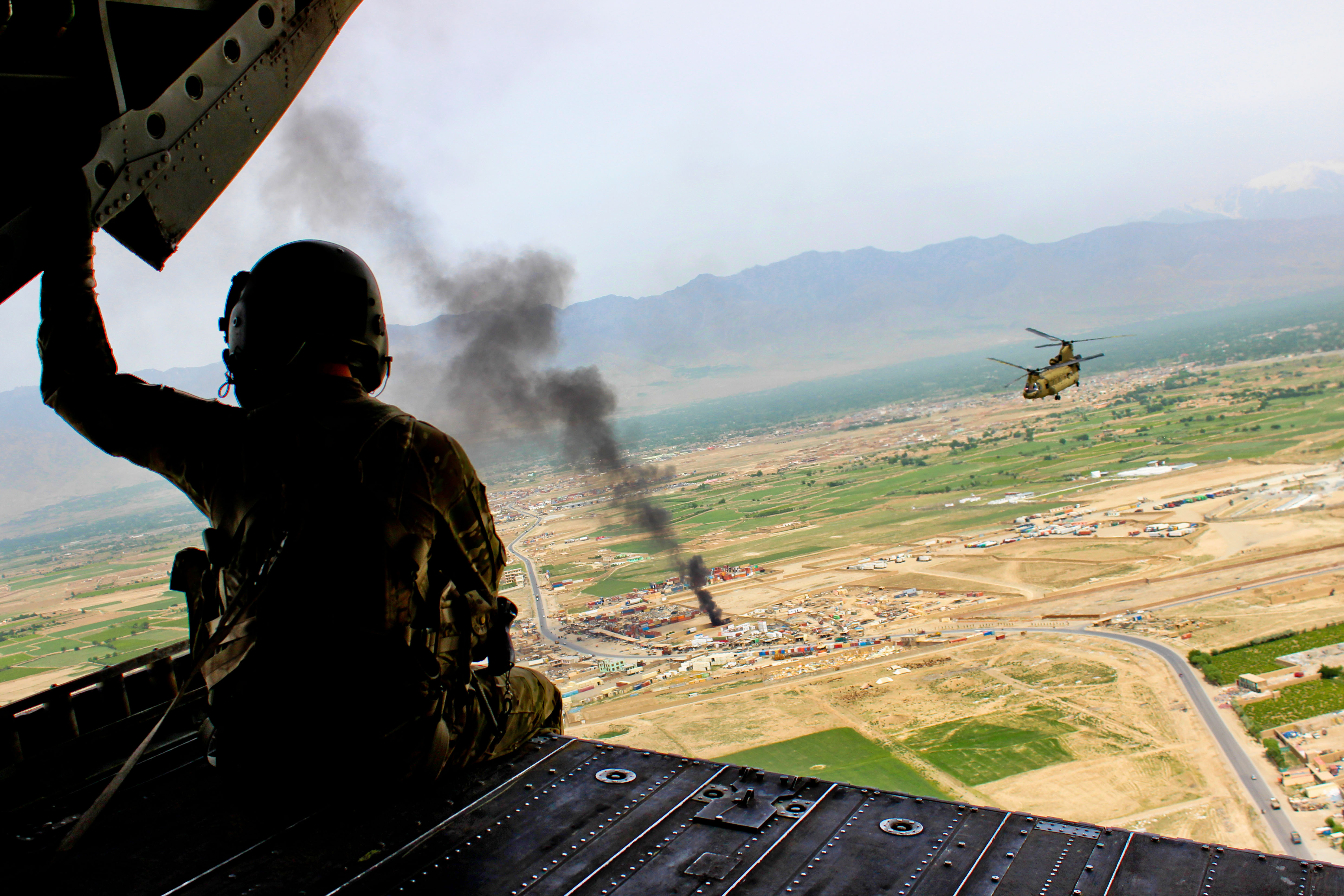 A U.S. soldier scans the ground from the tail ramp of a CH-47 Chinook ...