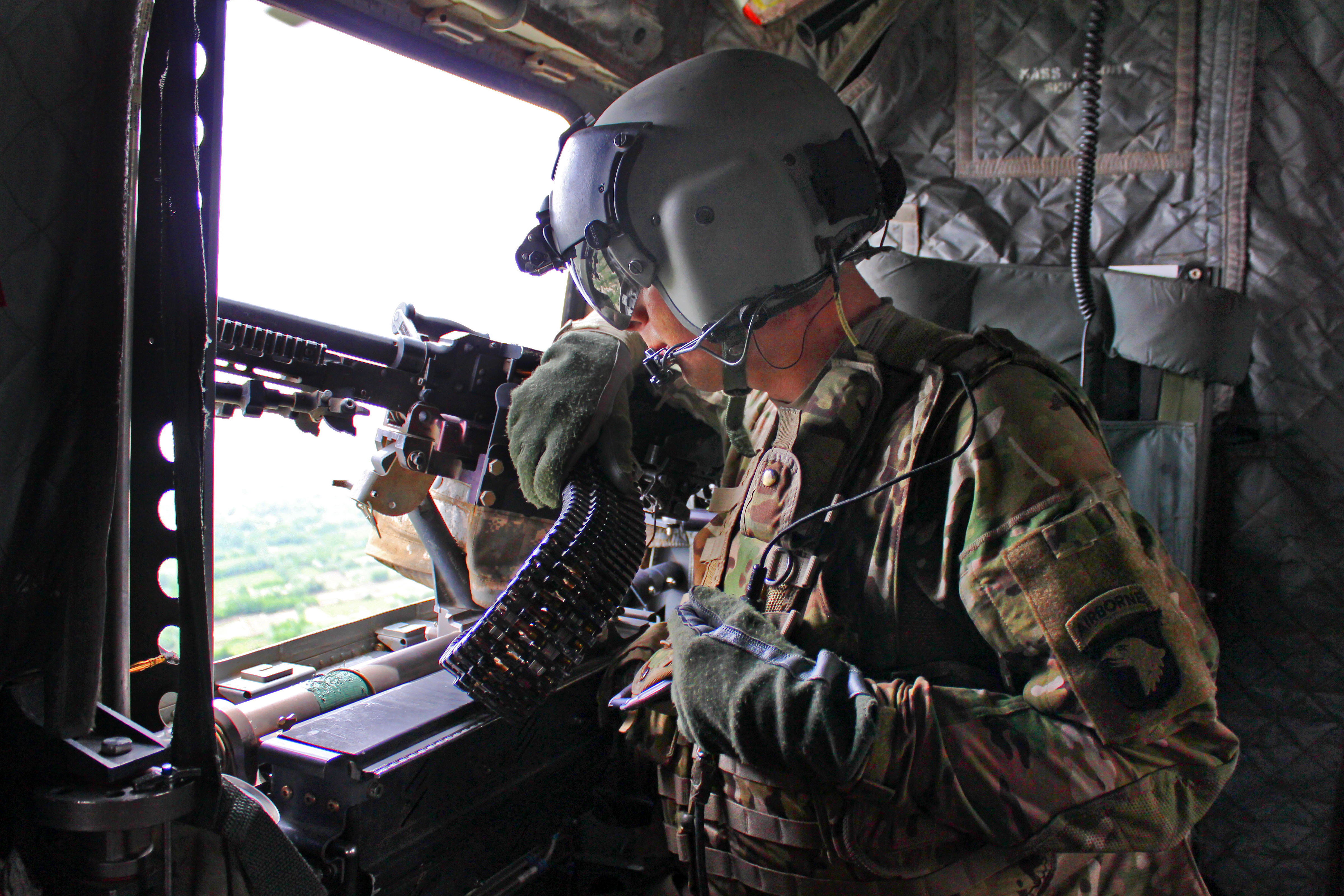 A U.S. soldier stands by his machine gun aboard a CH-47 Chinook ...