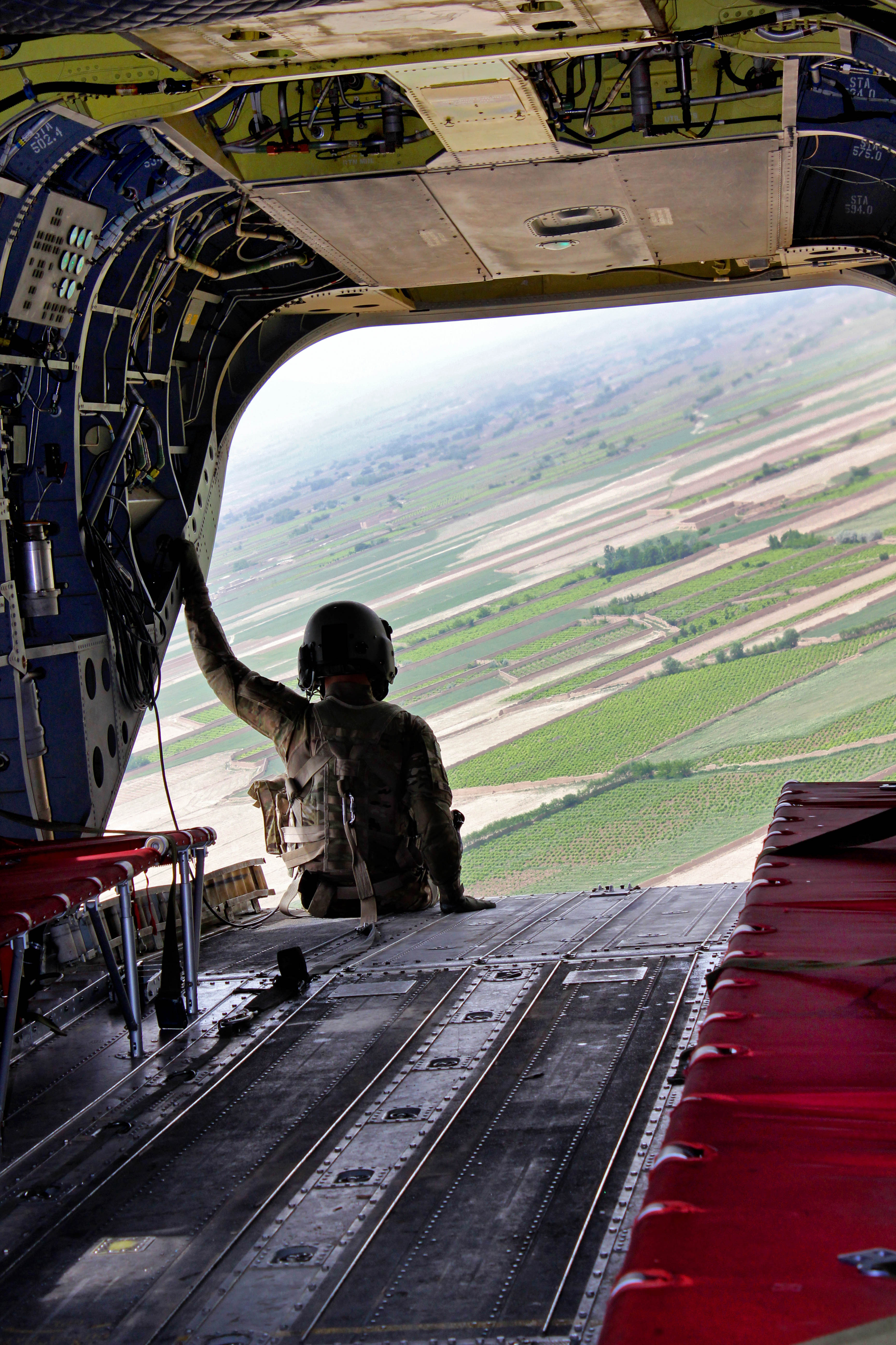 A U.S. soldier views the Afghan countryside from the tail ramp of a CH ...
