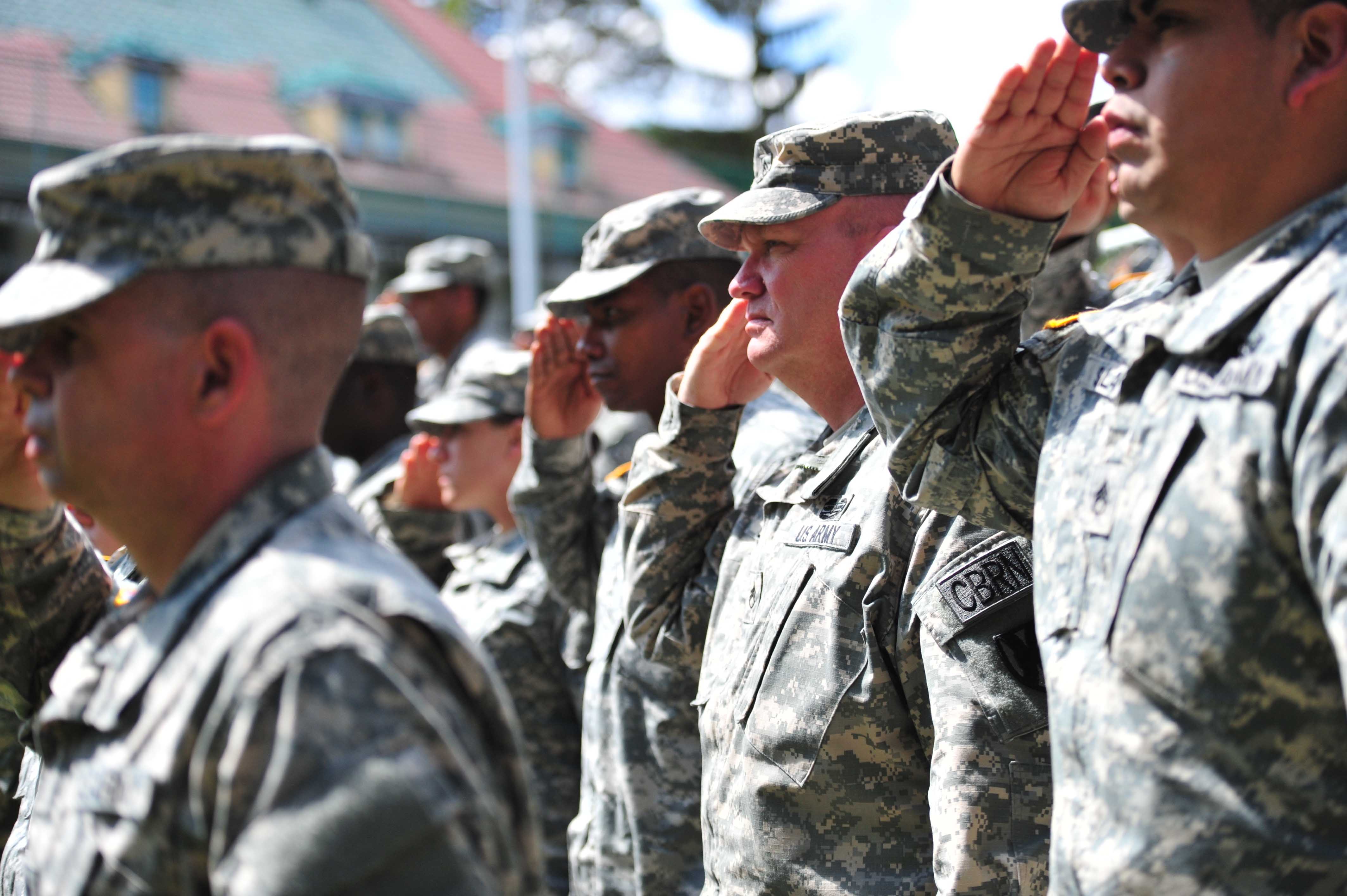 U.S. soldiers salute during the playing of the national anthem as part ...