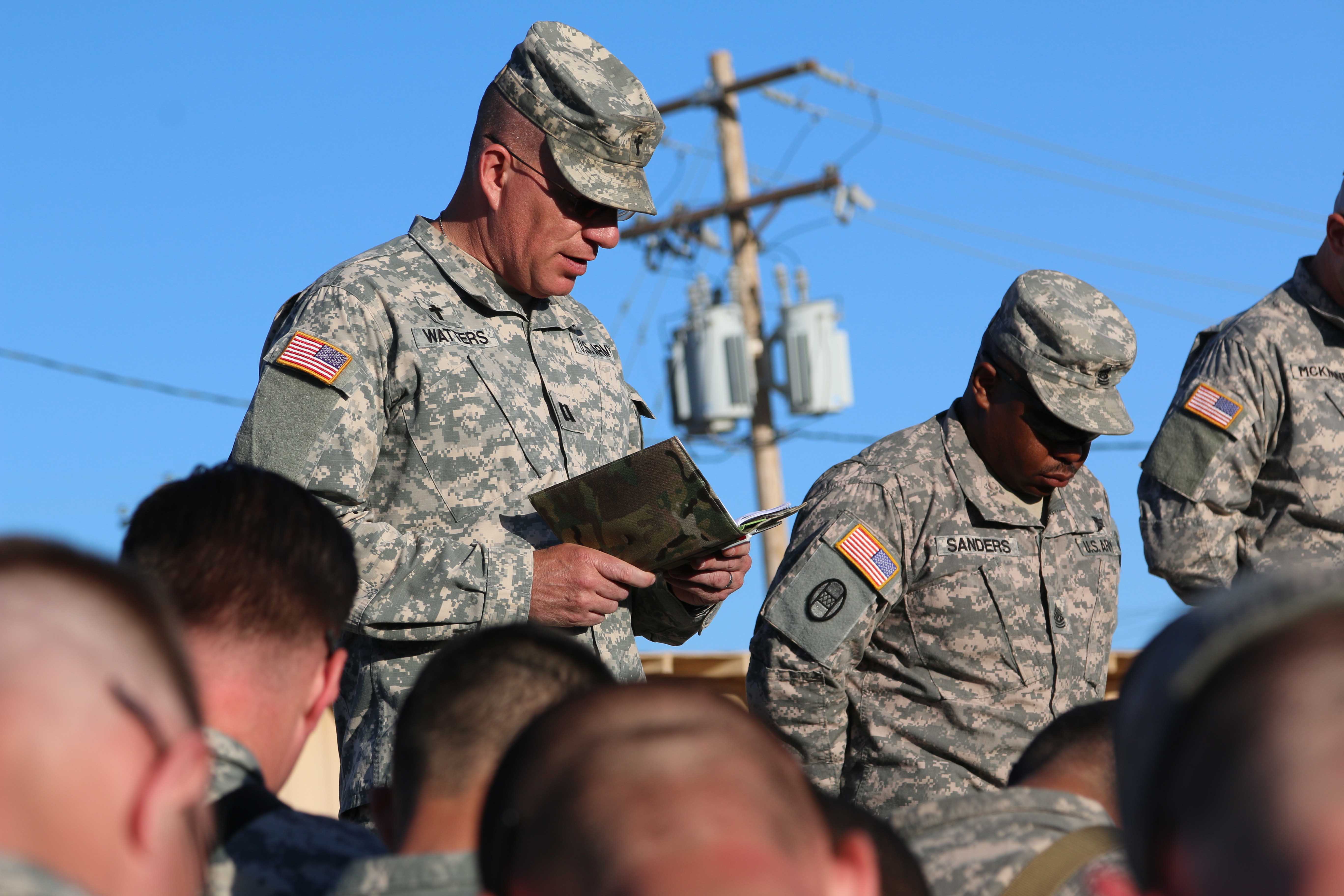 Army Capt. James Watters leads soldiers in prayer during a Memorial Day ...