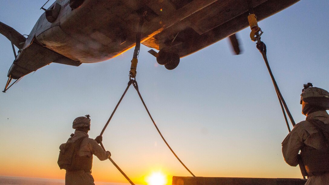 Marines with the 26th MEU perform lift at sunset on the beach