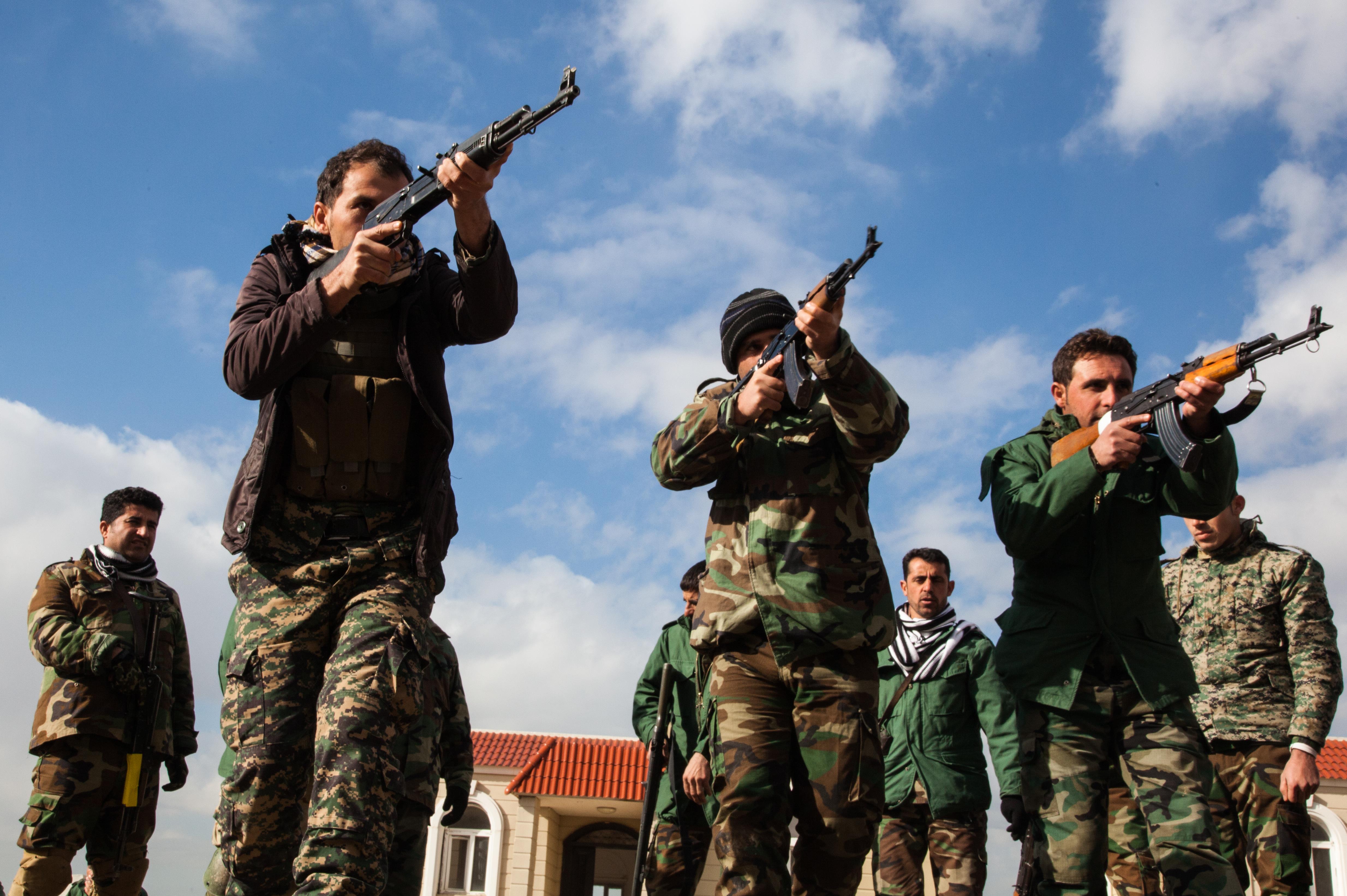 Peshmerga soldiers practice tactical movements and clearing a buildings